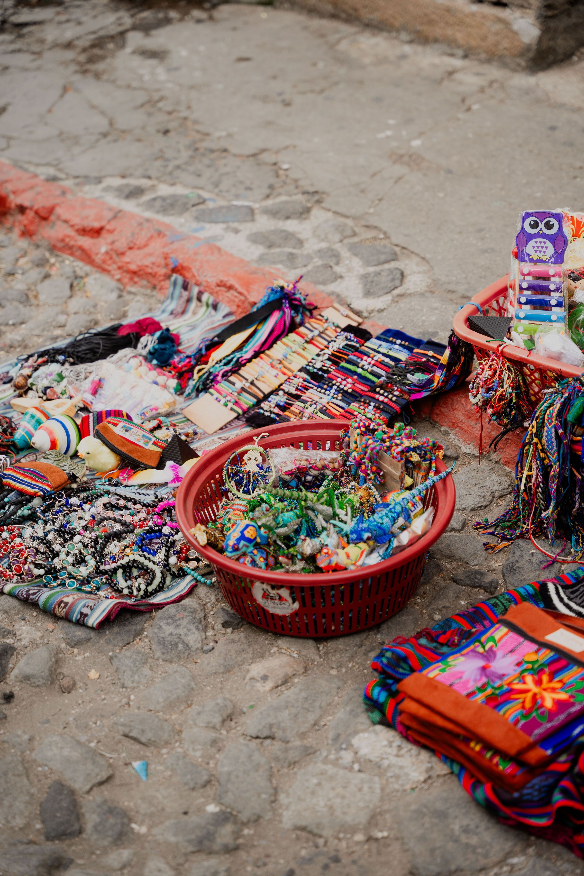 Colorful Handicrafts Display on Cobblestone Street · Free Stock Photo