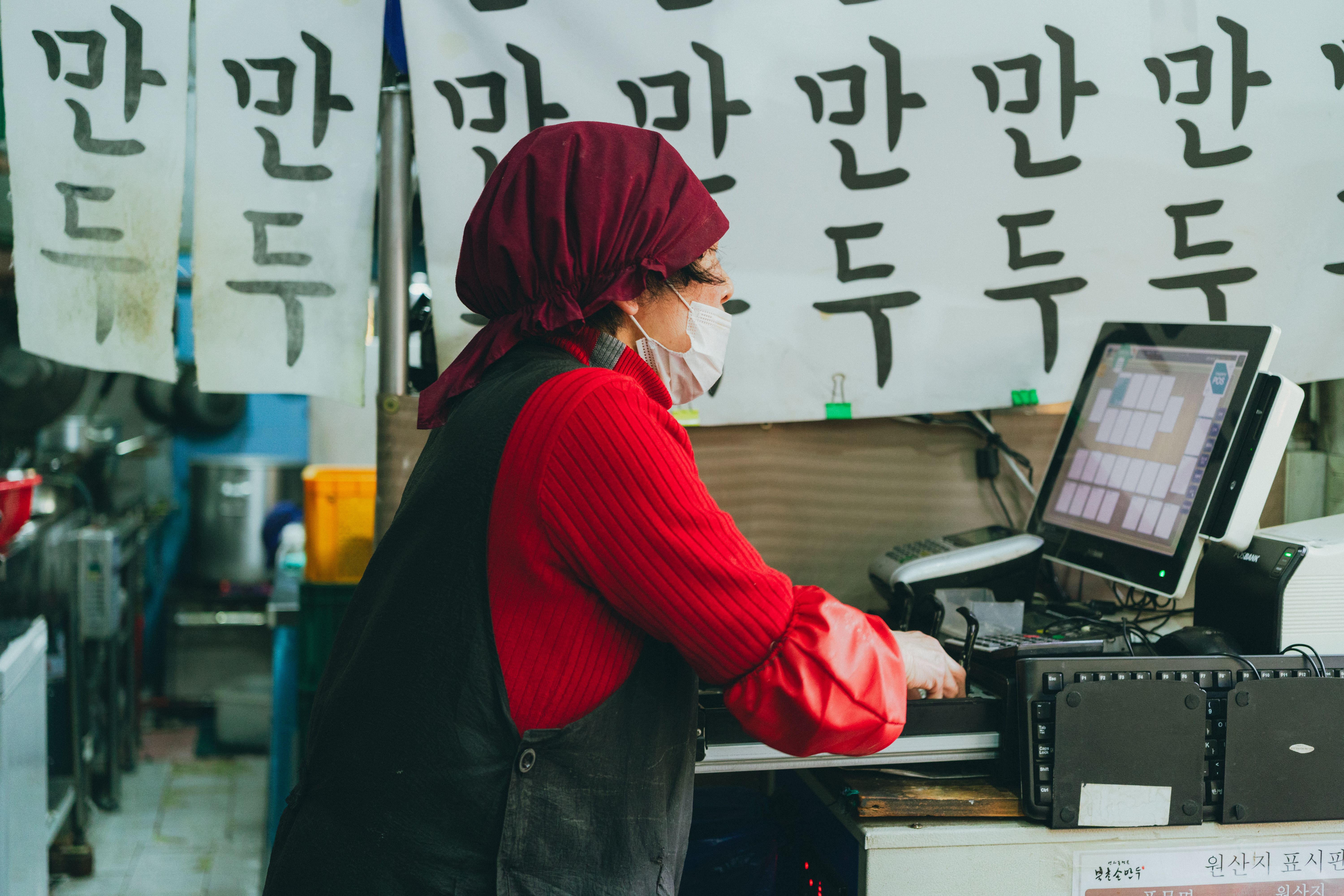 Woman in Seoul Street Market with Korean Script Signs · Free Stock Photo