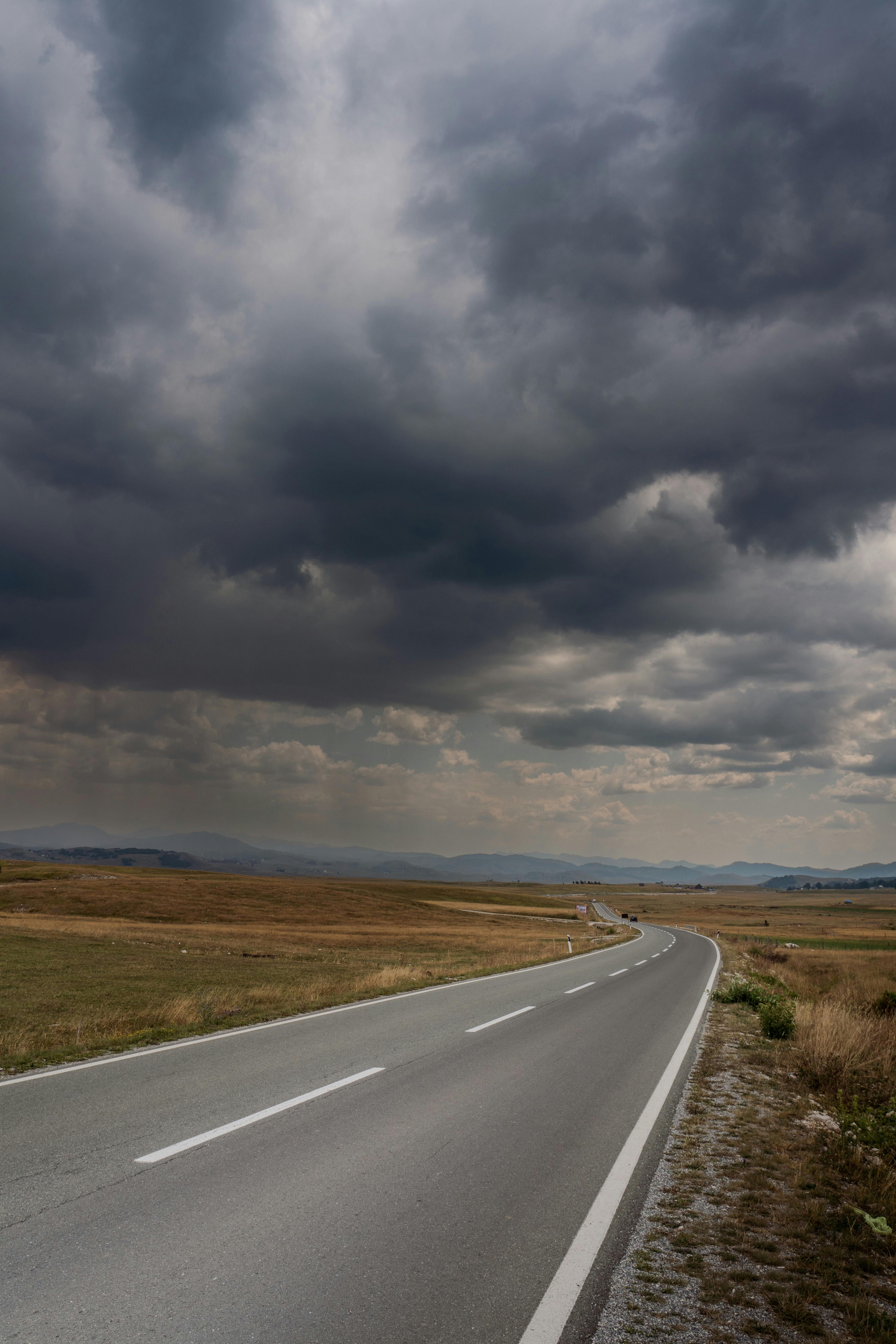 Dramatic Overcast Road in Vast Open Landscape · Free Stock Photo