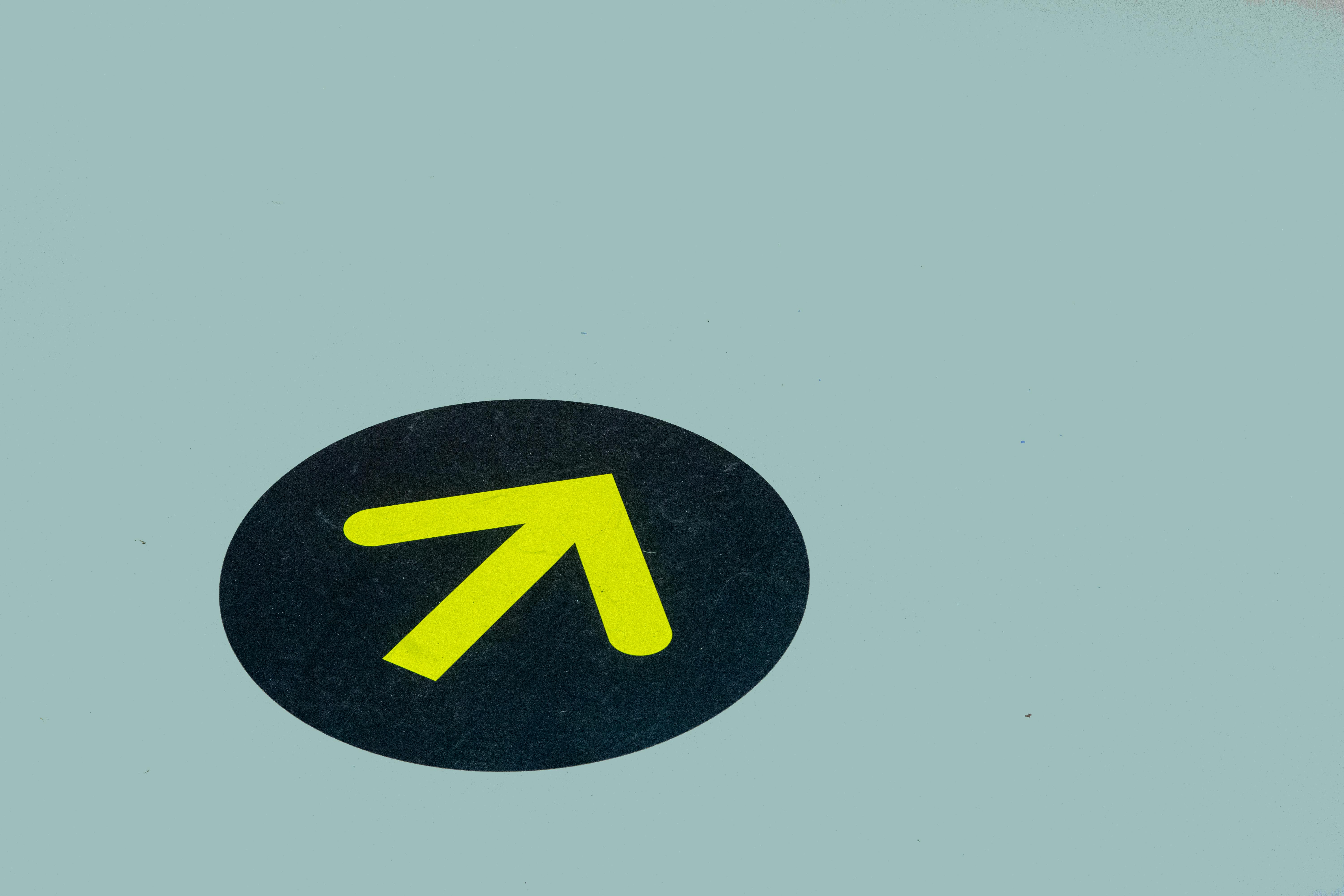 Yellow Arrow on Blue Floor for Directional Guide · Free Stock Photo