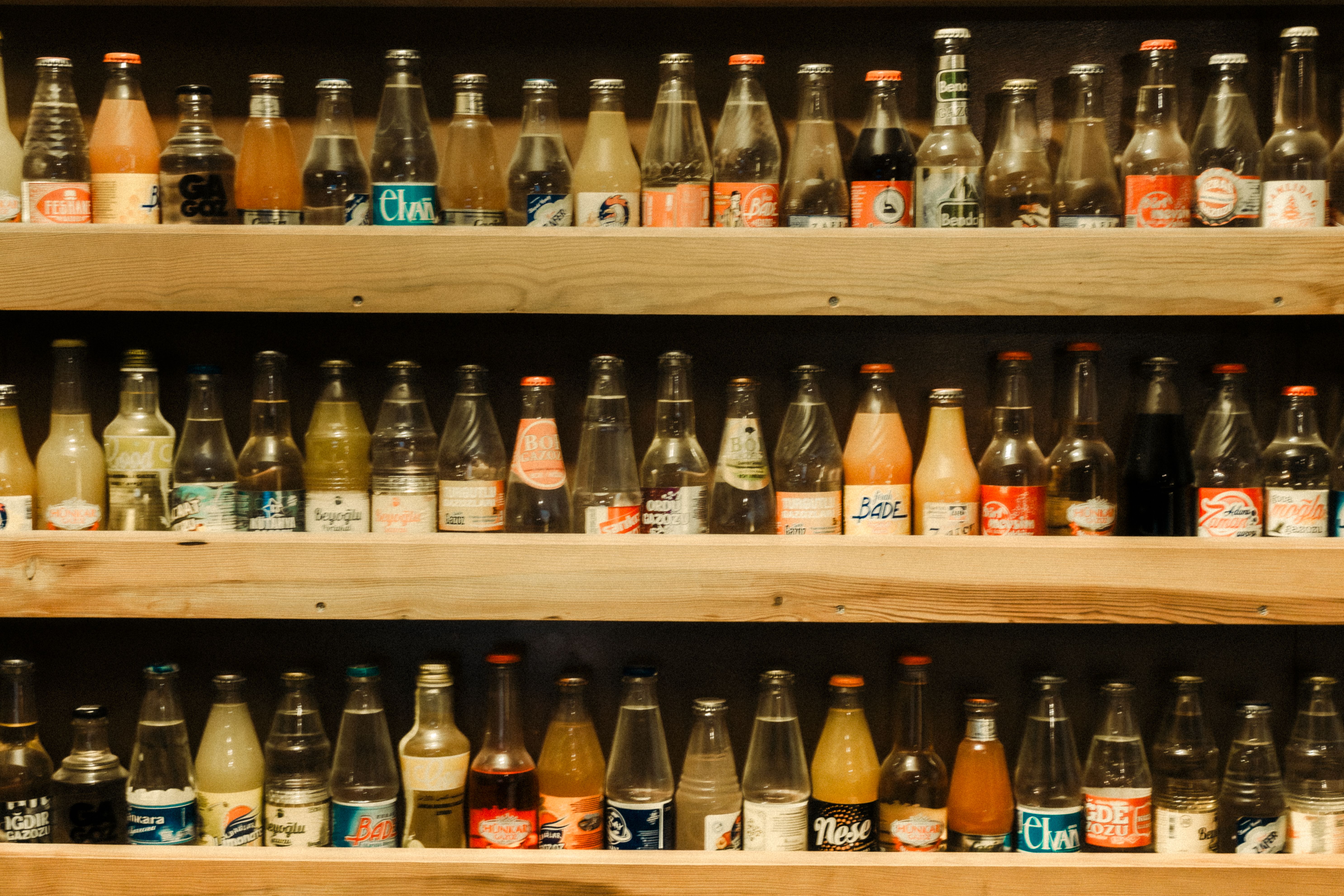 Shelf Display of Vintage Soda Bottles in Rows · Free Stock Photo