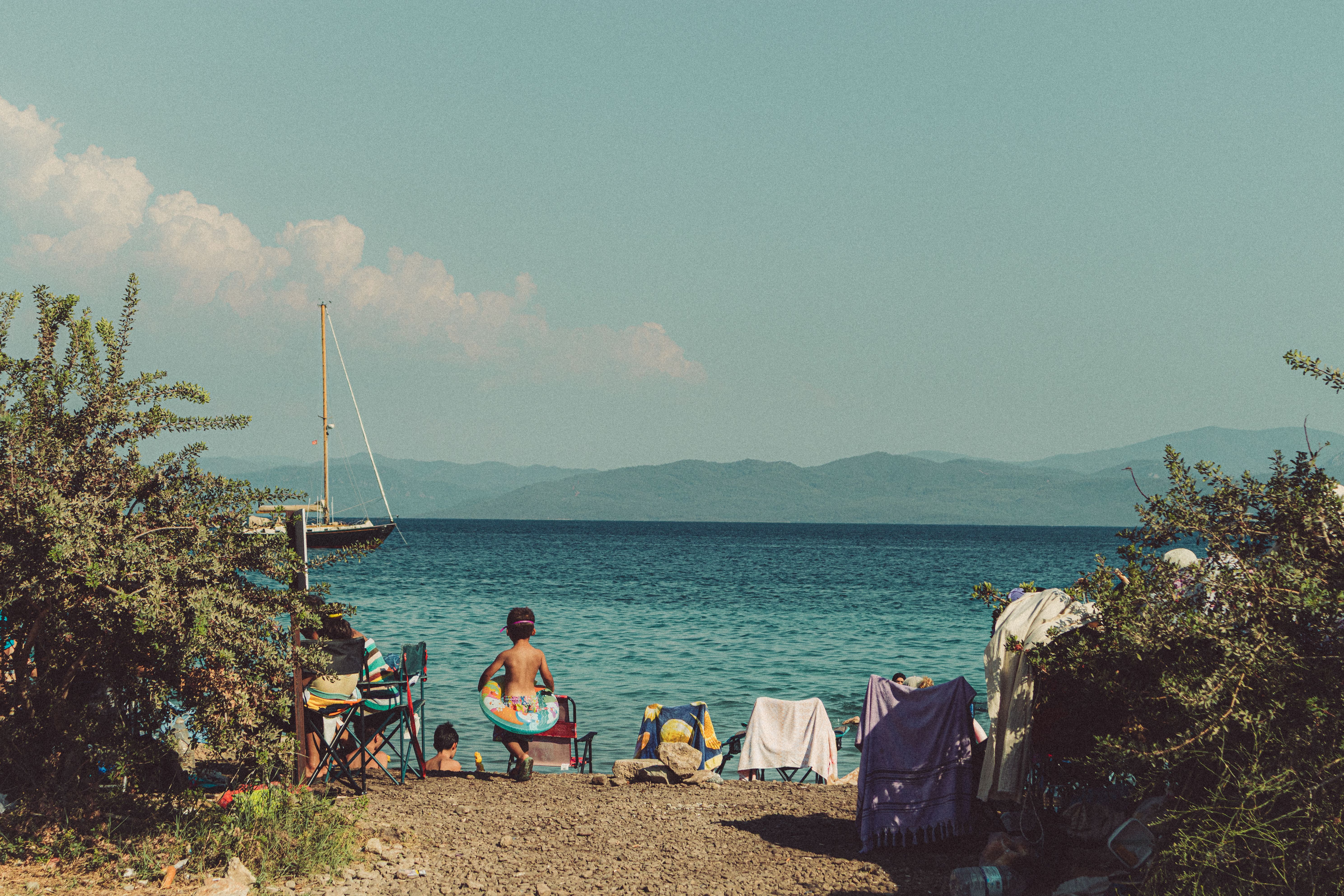 Relaxing Beach Day by the Sea with Sailboat · Free Stock Photo