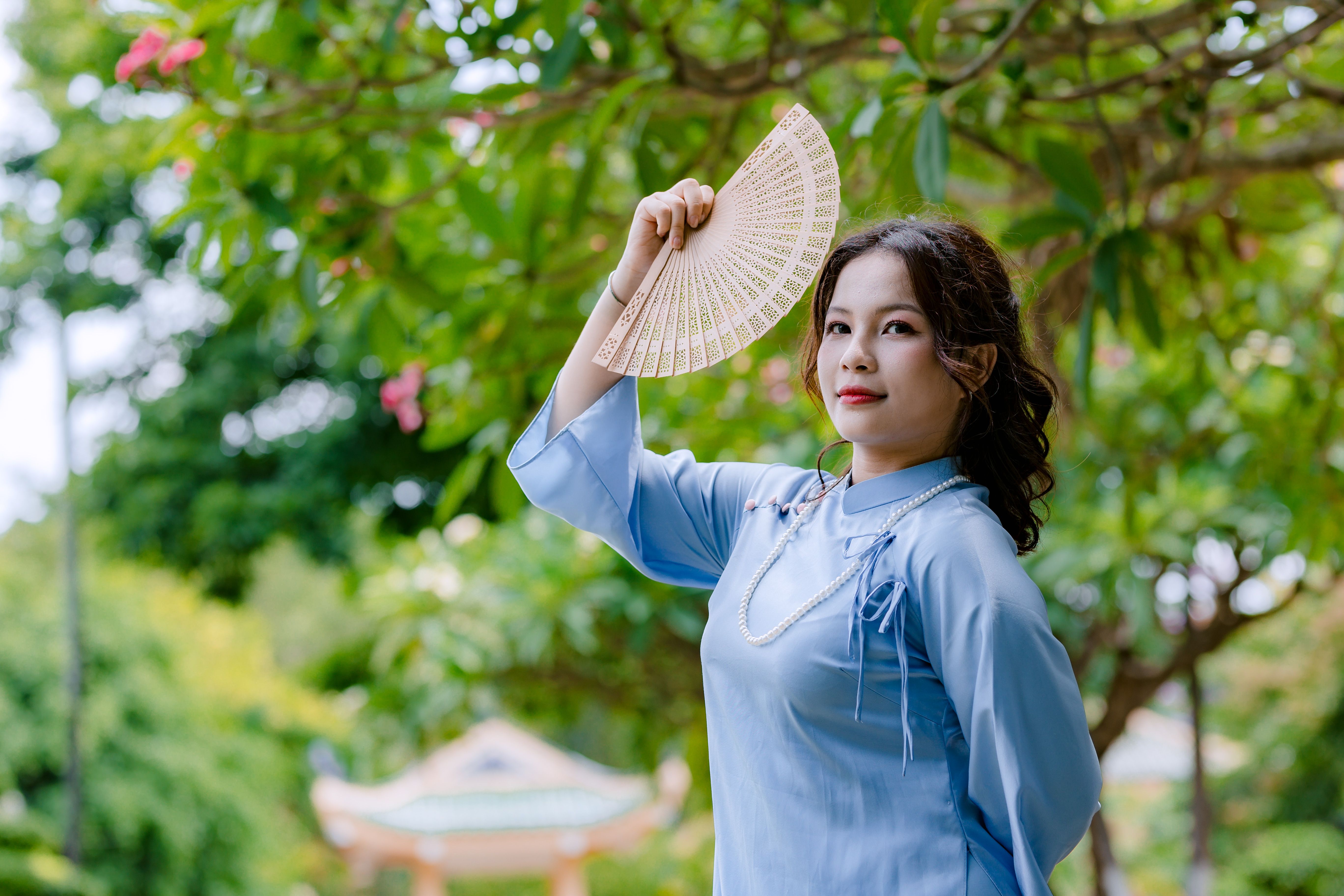 Elegant Woman in Blue Cheongsam with Fan Outdoors · Free Stock Photo