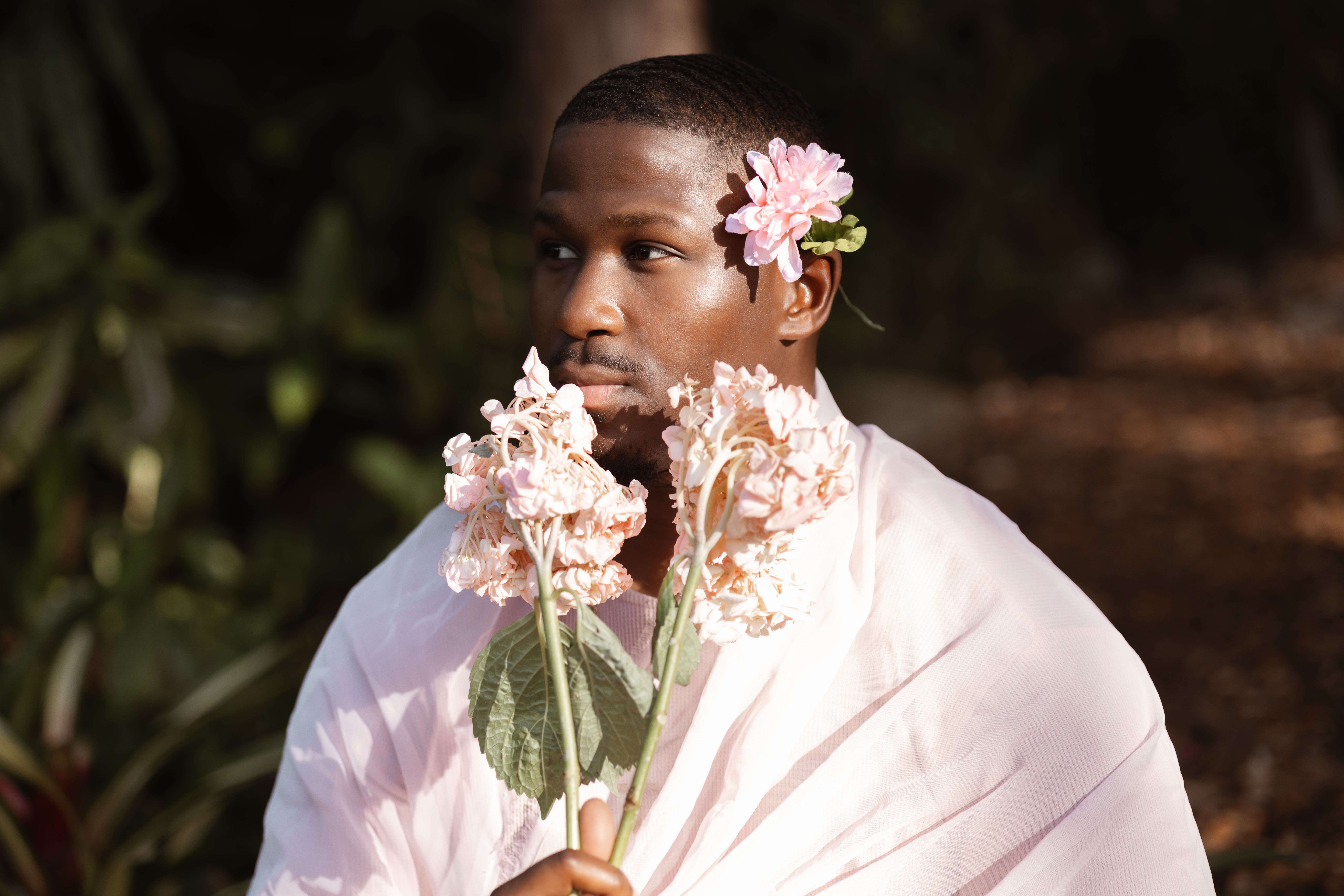Man with Flowers Outdoors in Sunlight · Free Stock Photo