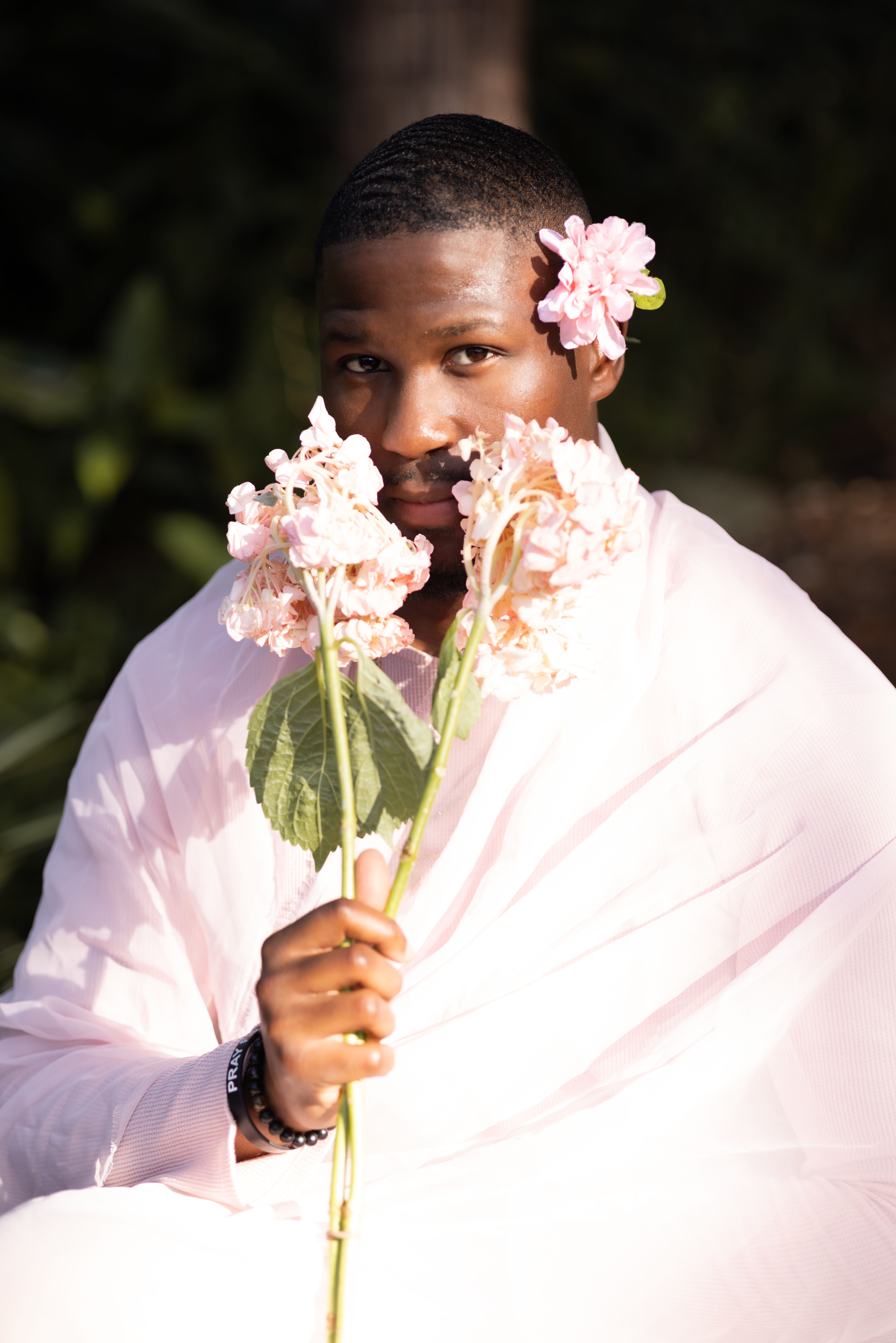 Man in Pink Holding Flowers in Garden Setting · Free Stock Photo
