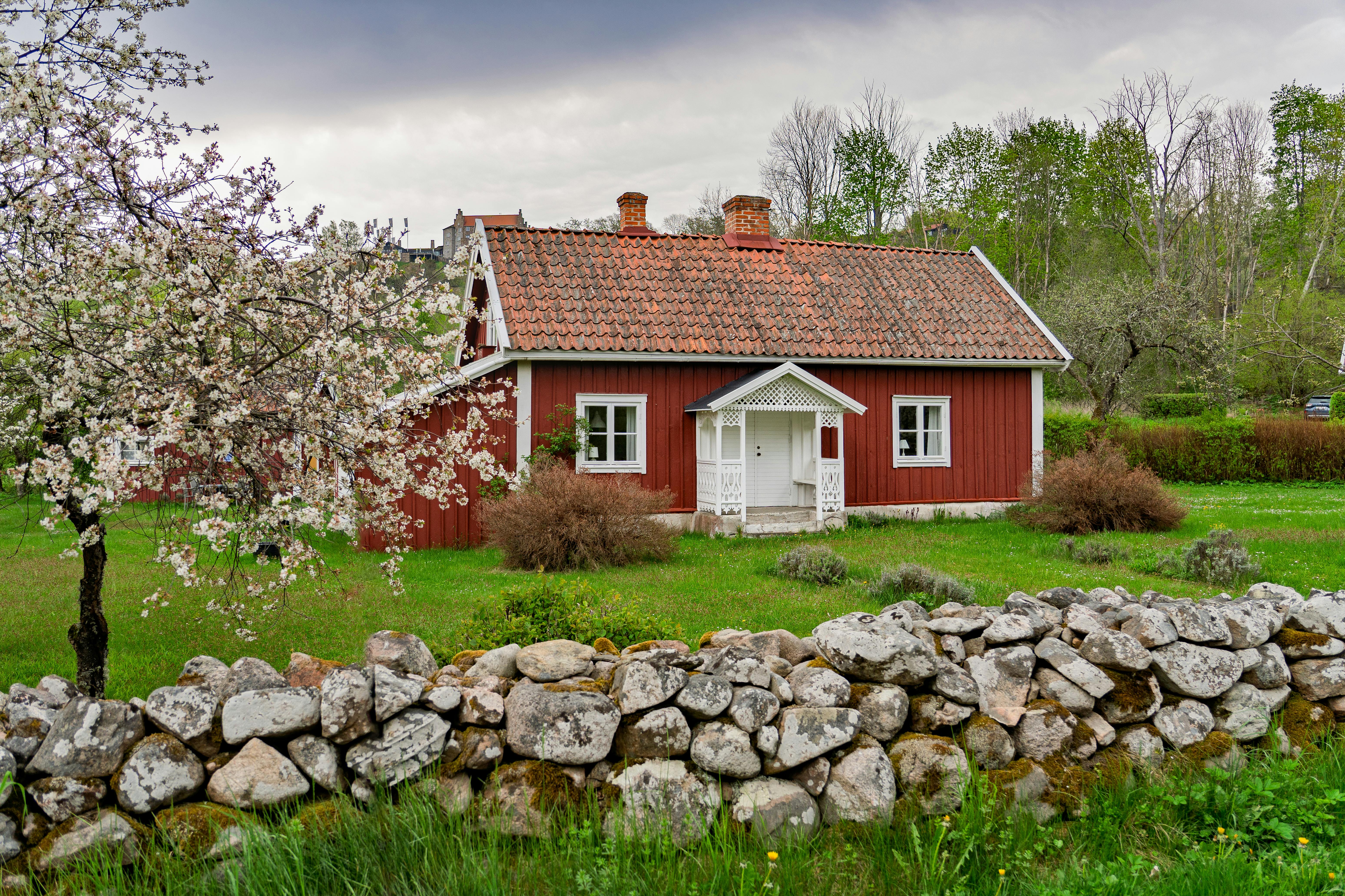 Rustic Red Cottage with Blooming Cherry Trees · Free Stock Photo