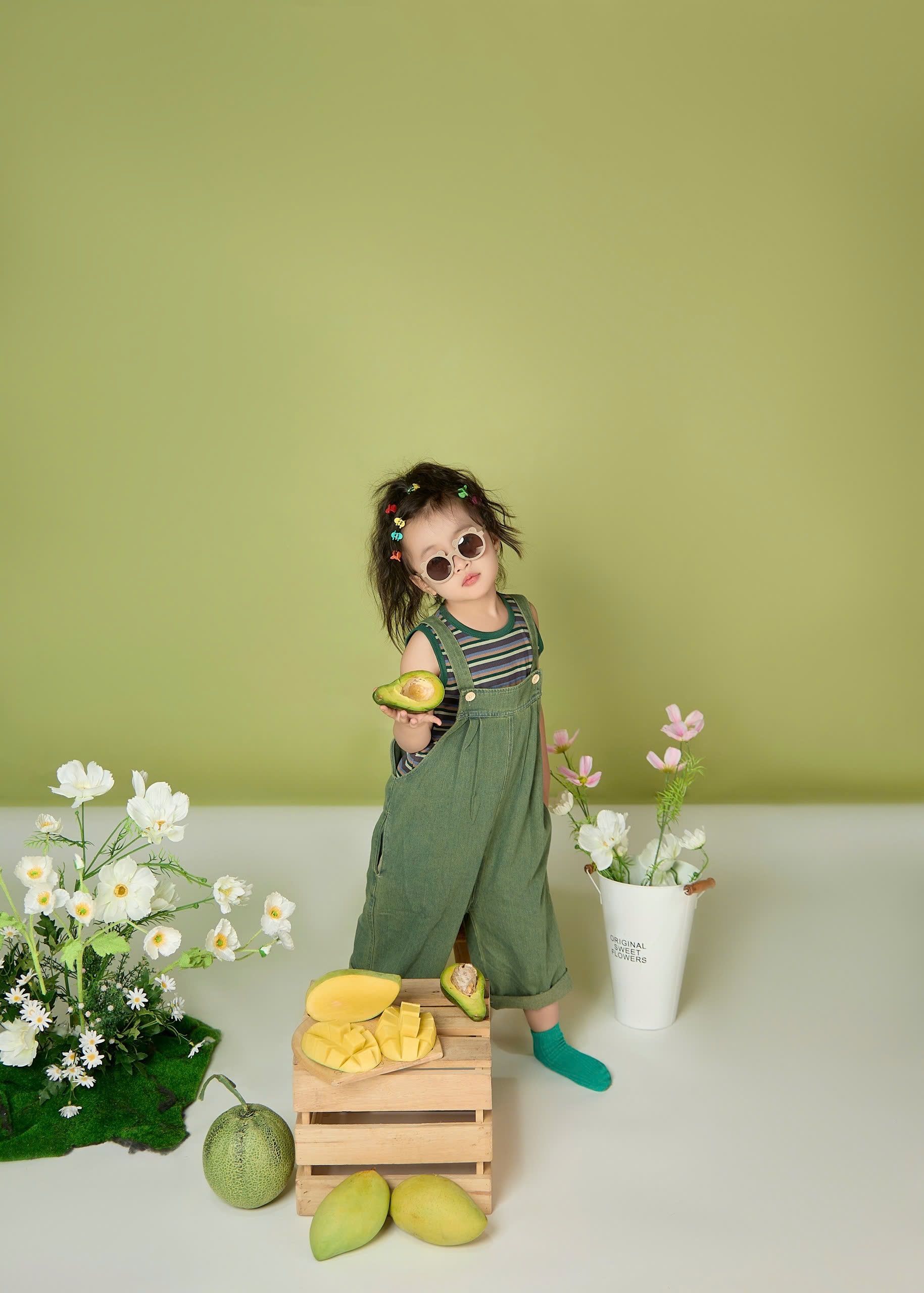 Adorable Child with Sunglasses Among Flowers and Fruits · Free Stock Photo