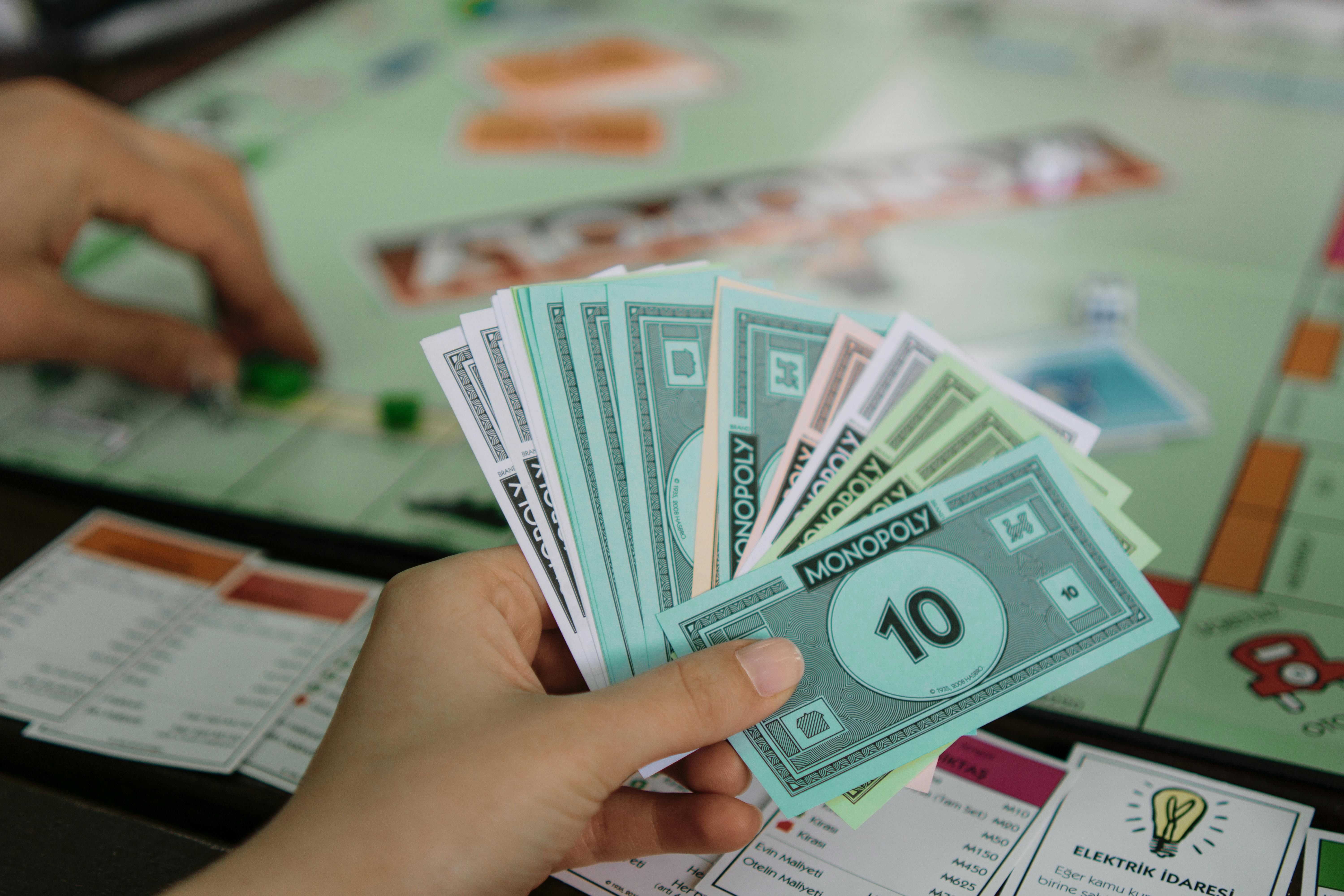 Close-up of Hands Playing Monopoly Game · Free Stock Photo