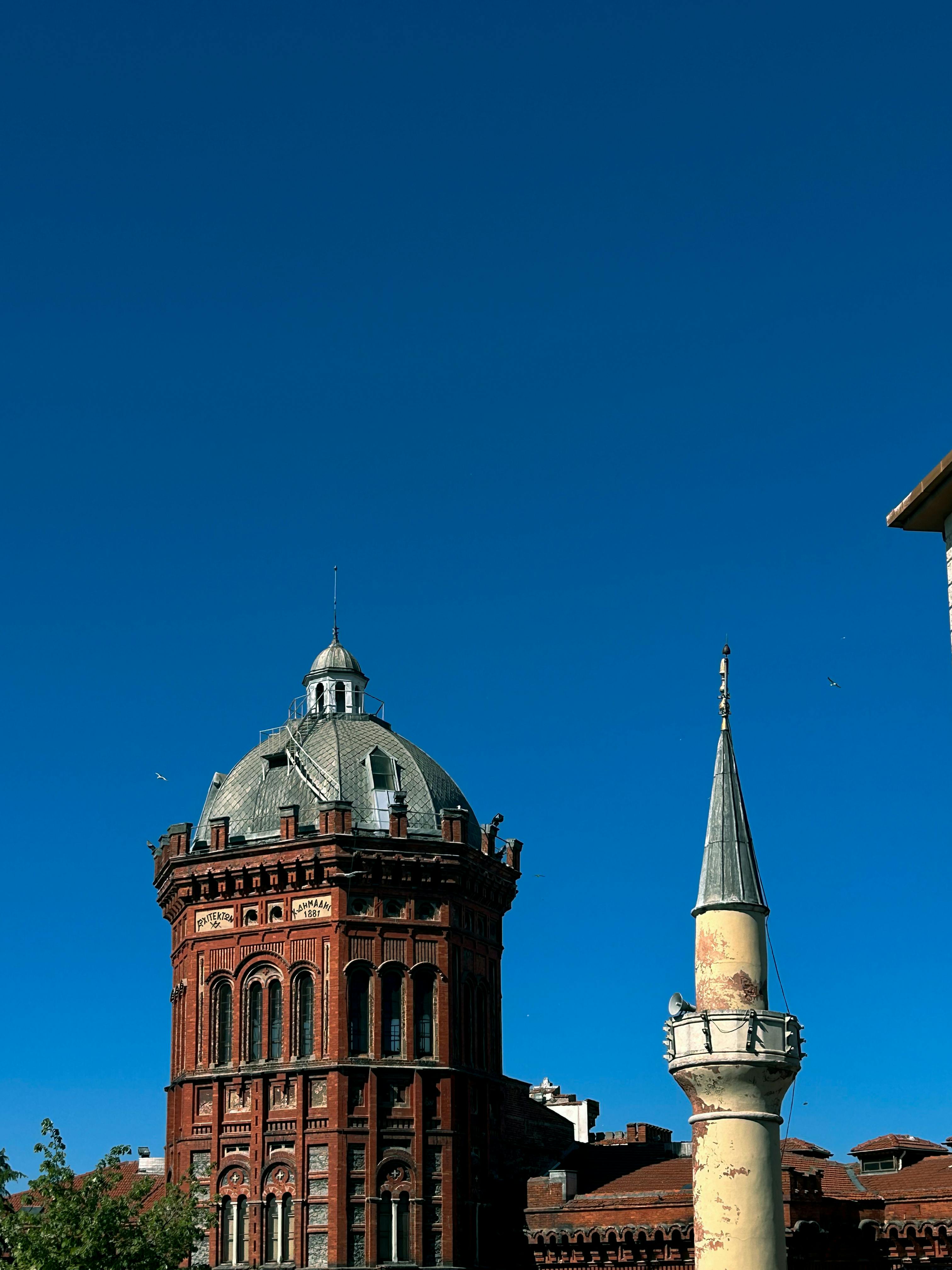Red Brick Dome and Minaret Against Clear Sky · Free Stock Photo