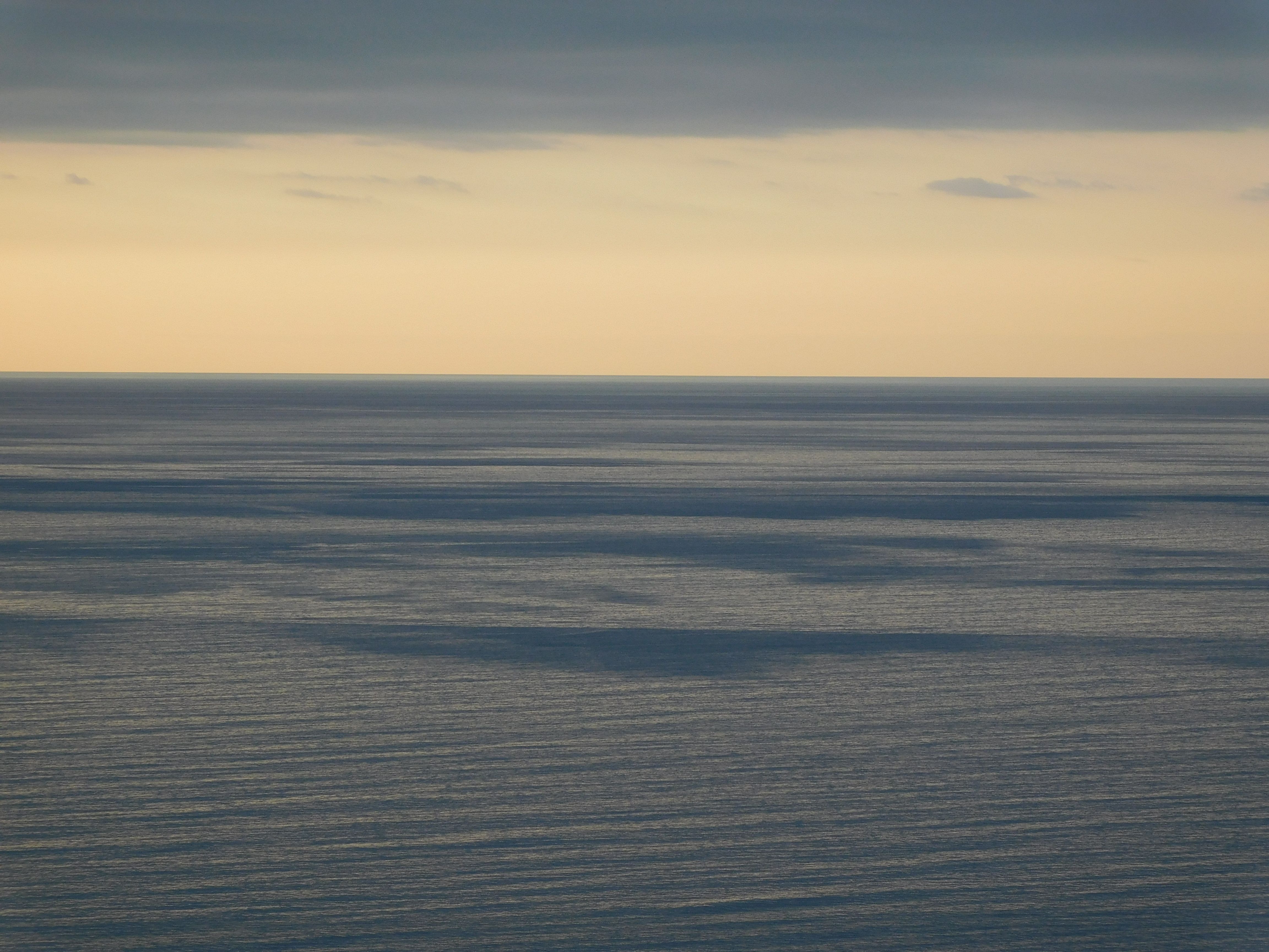Serene Ocean Horizon Under Overcast Sky · Free Stock Photo