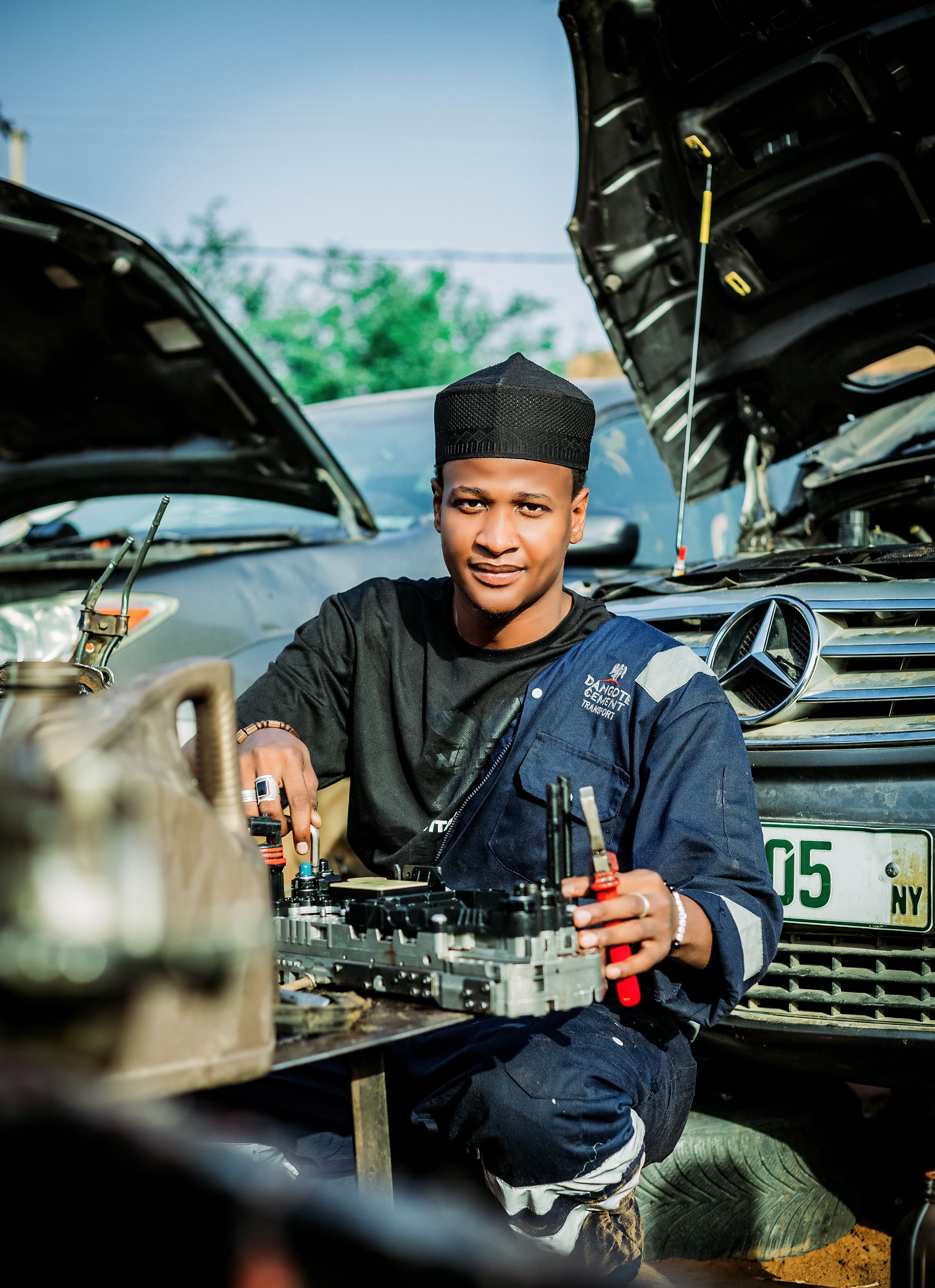 Skilled Mechanic Working on Car Engine Outdoors · Free Stock Photo