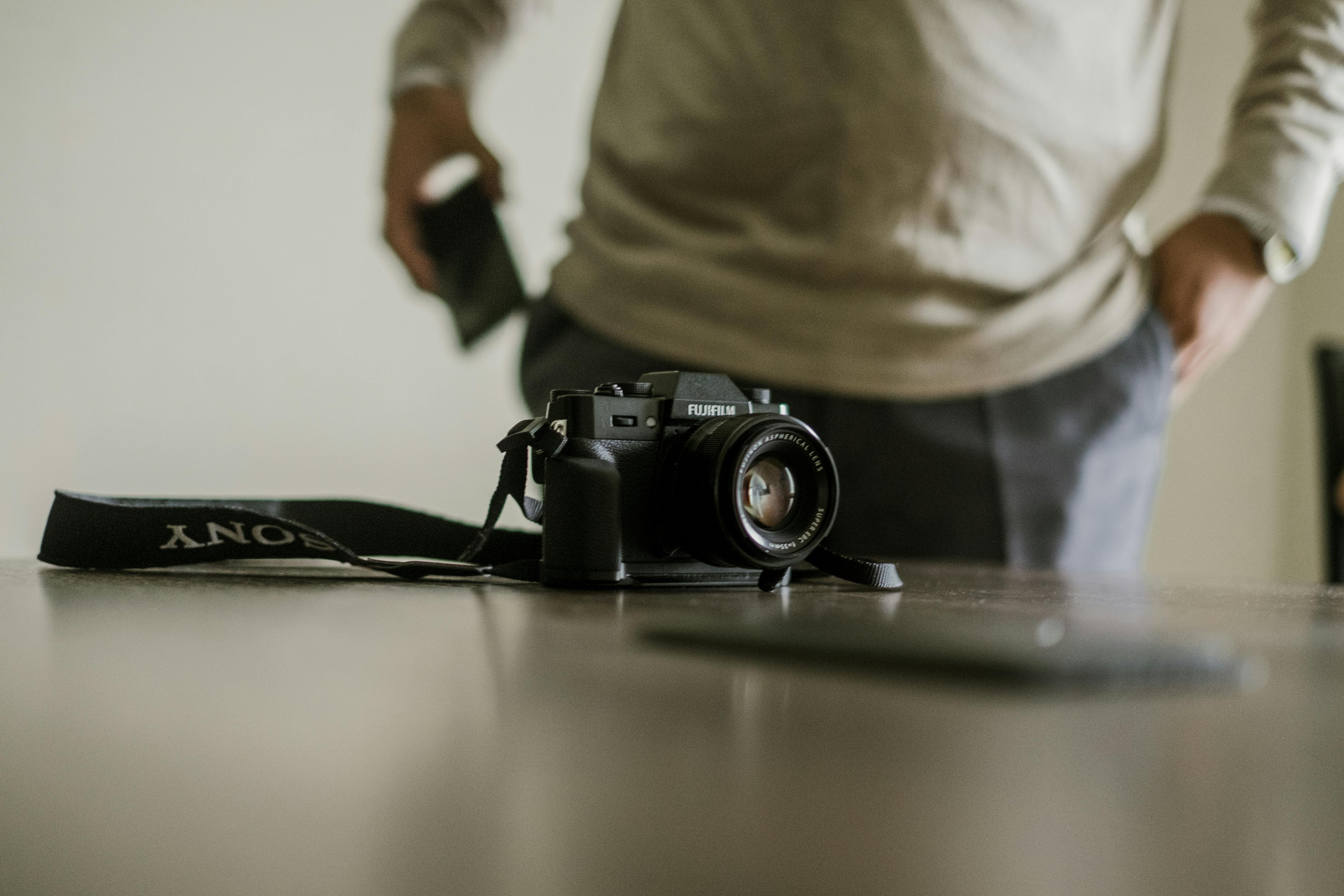 Camera on Table Near Man · Free Stock Photo