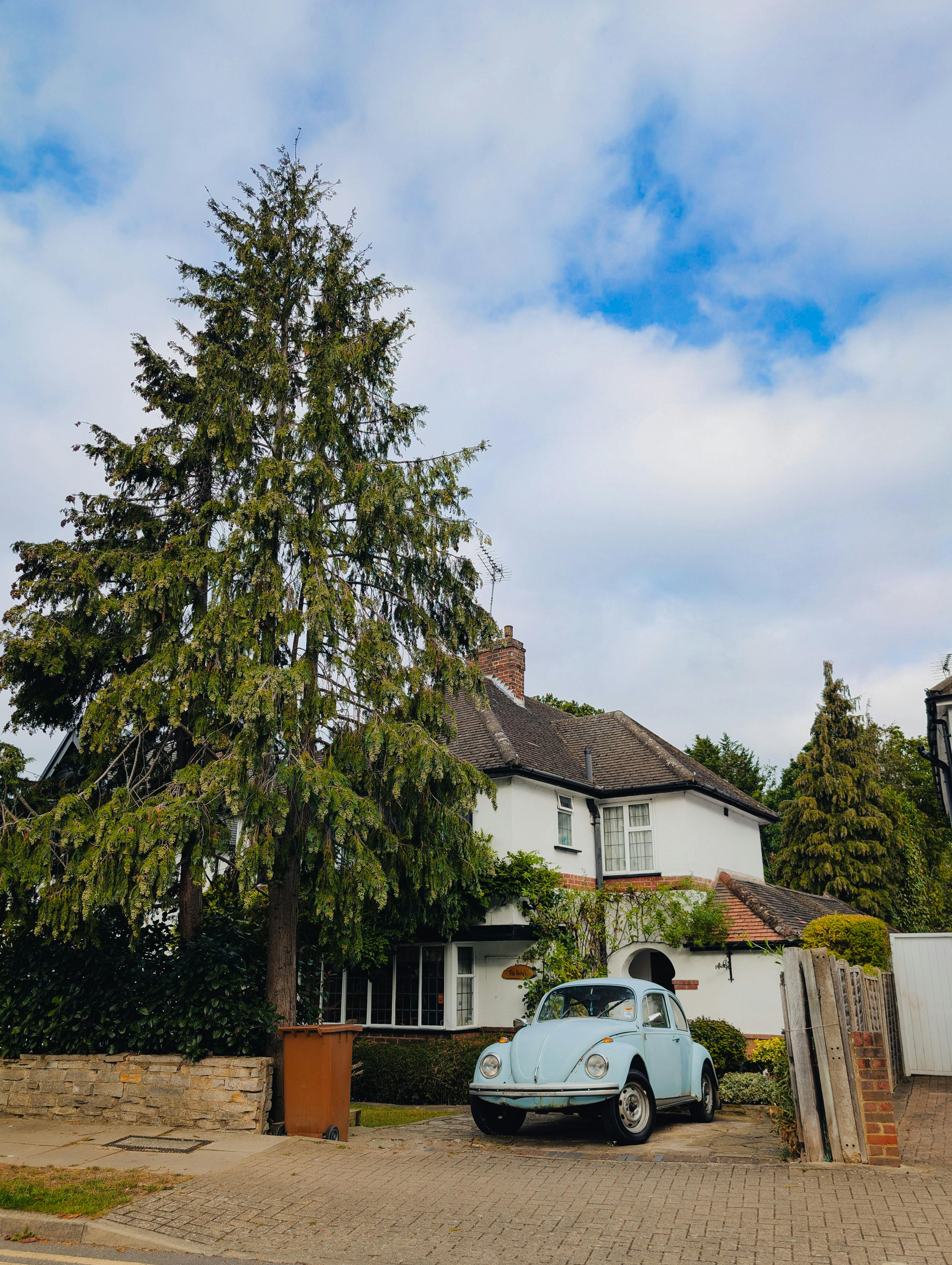Vintage Car Parked by Quaint Cottage in Suburbia · Free Stock Photo