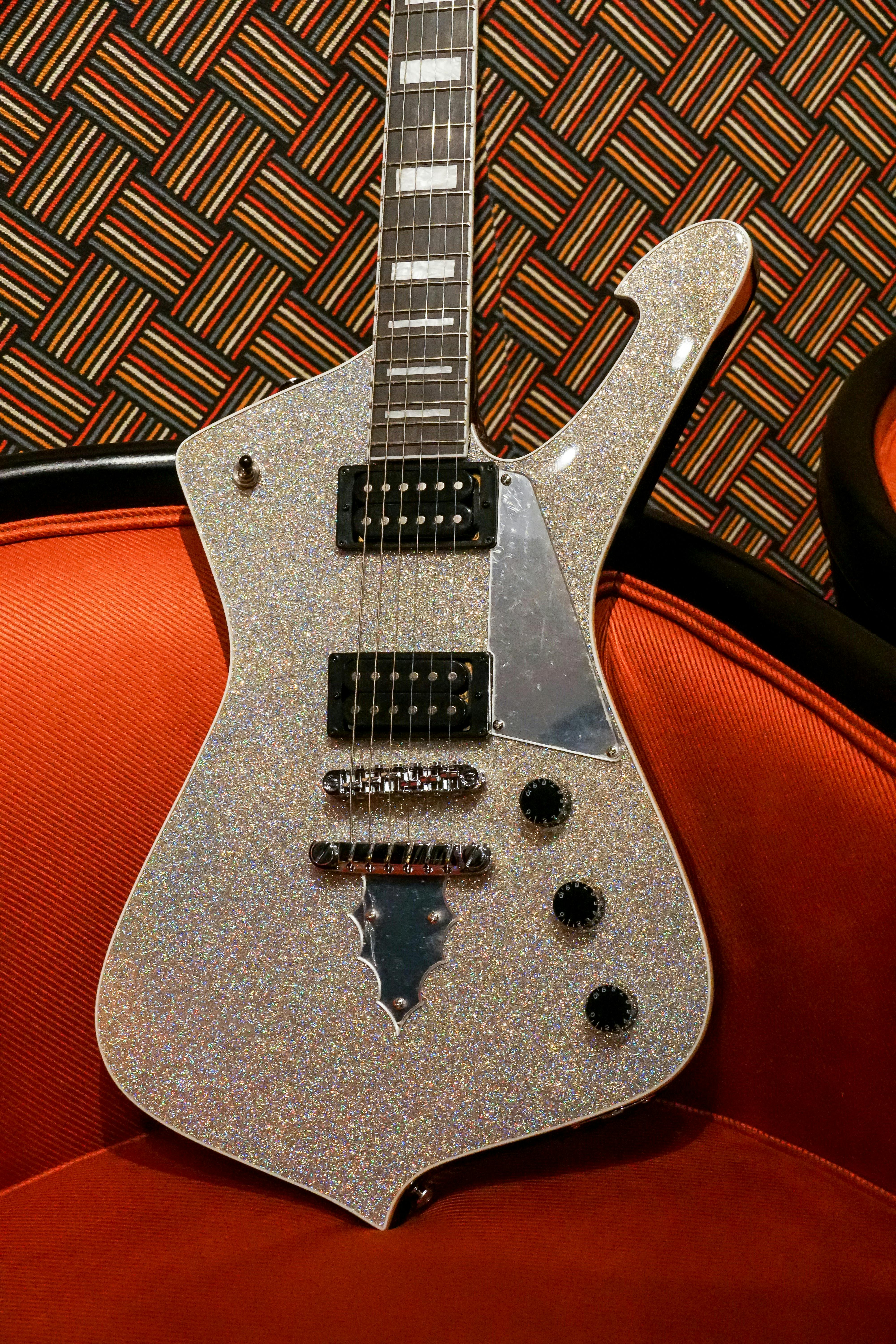 Sparkling Electric Guitar on Red Chair · Free Stock Photo