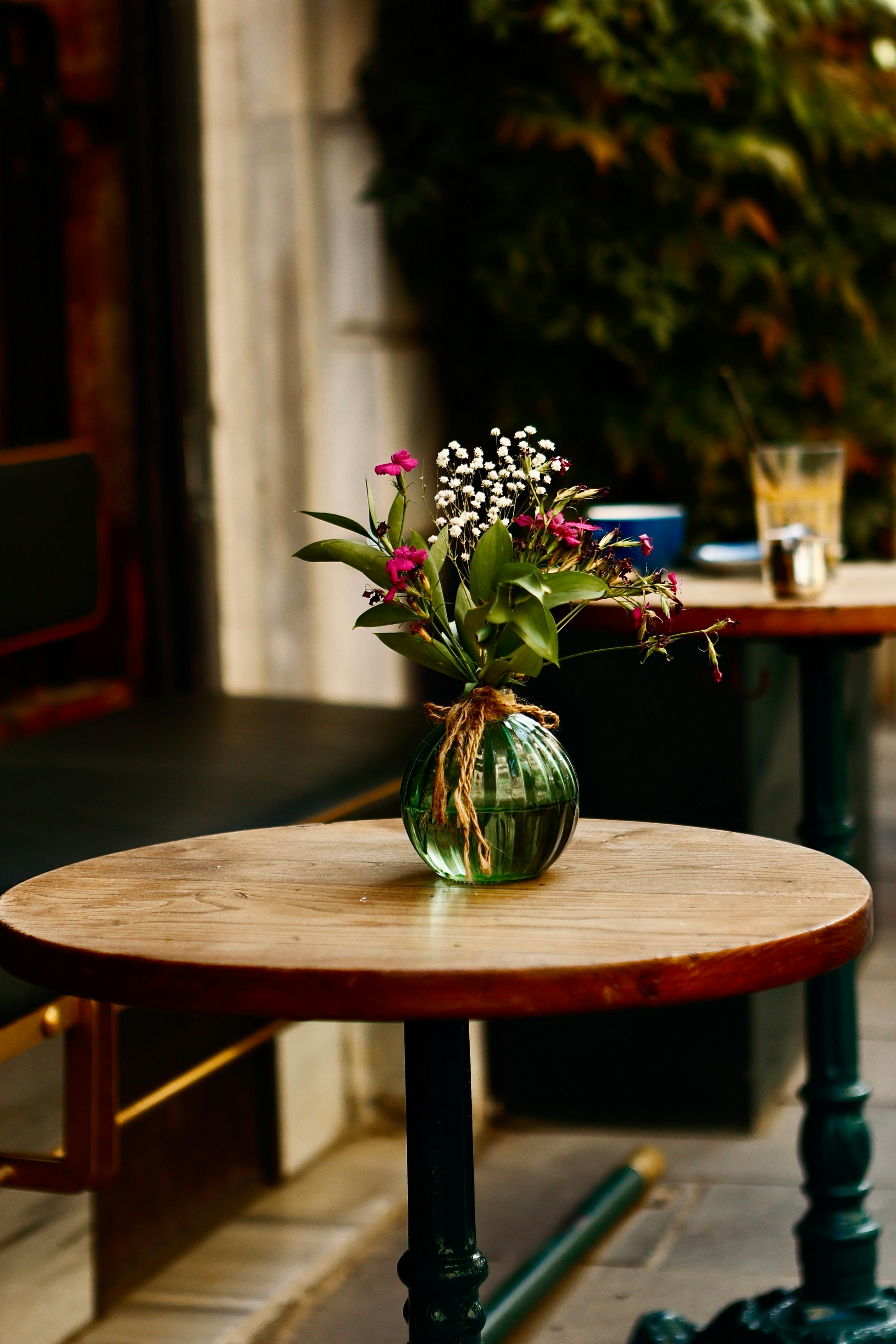 Rustic Café Table with Floral Arrangement · Free Stock Photo