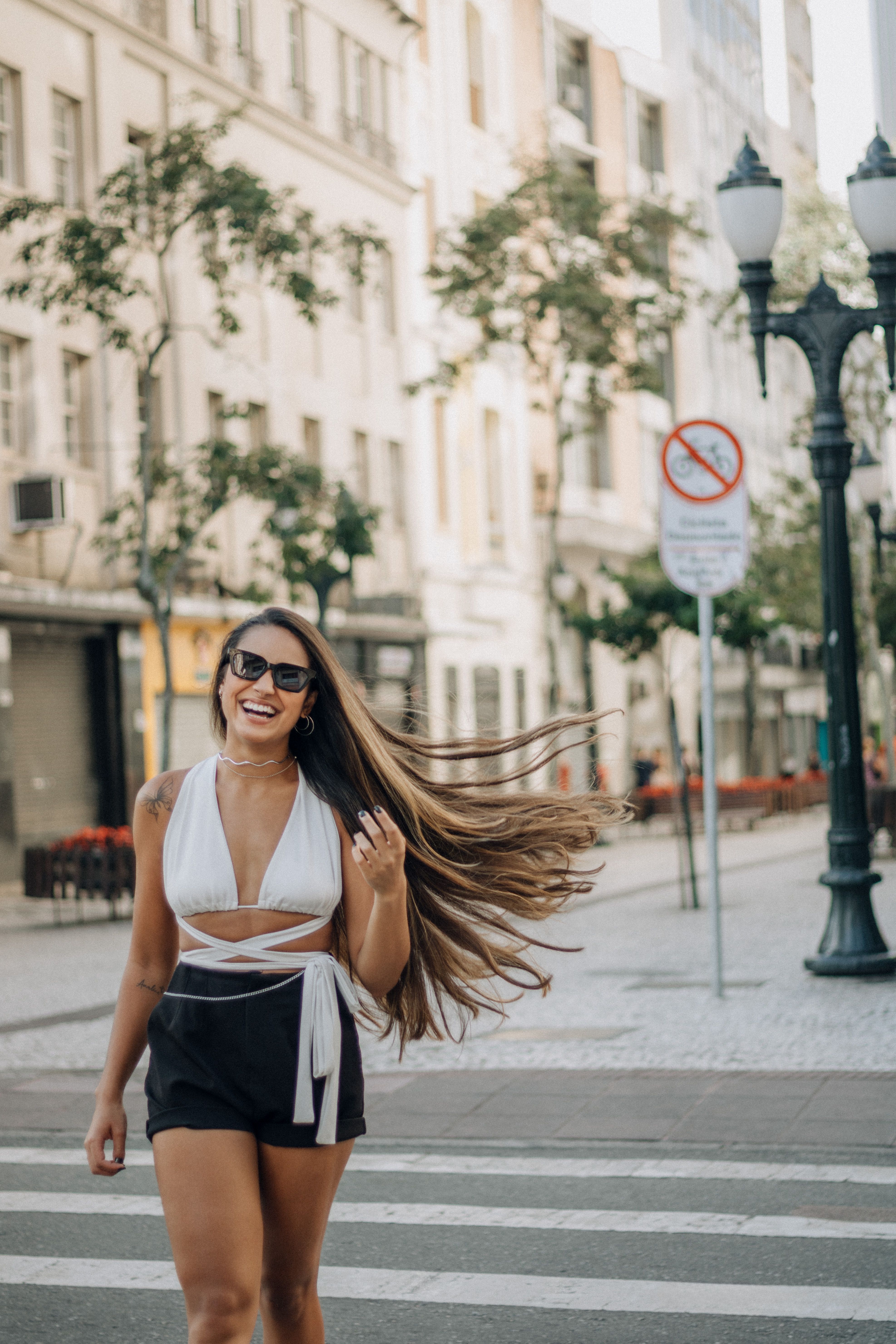 Cheerful Woman Walking Down City Street in Summer · Free Stock Photo