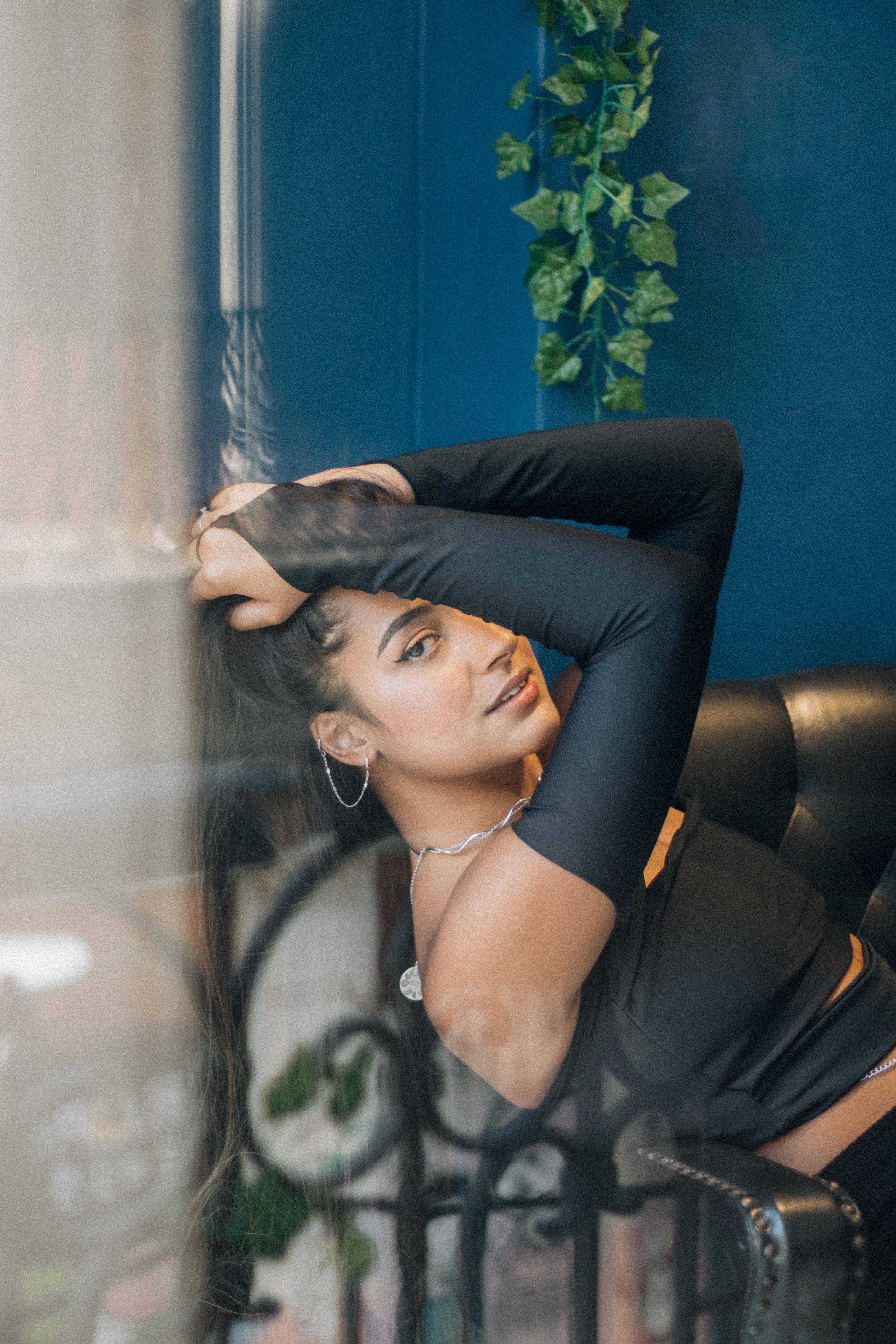 Stylish Woman Posing Indoors with Blue Background · Free Stock Photo