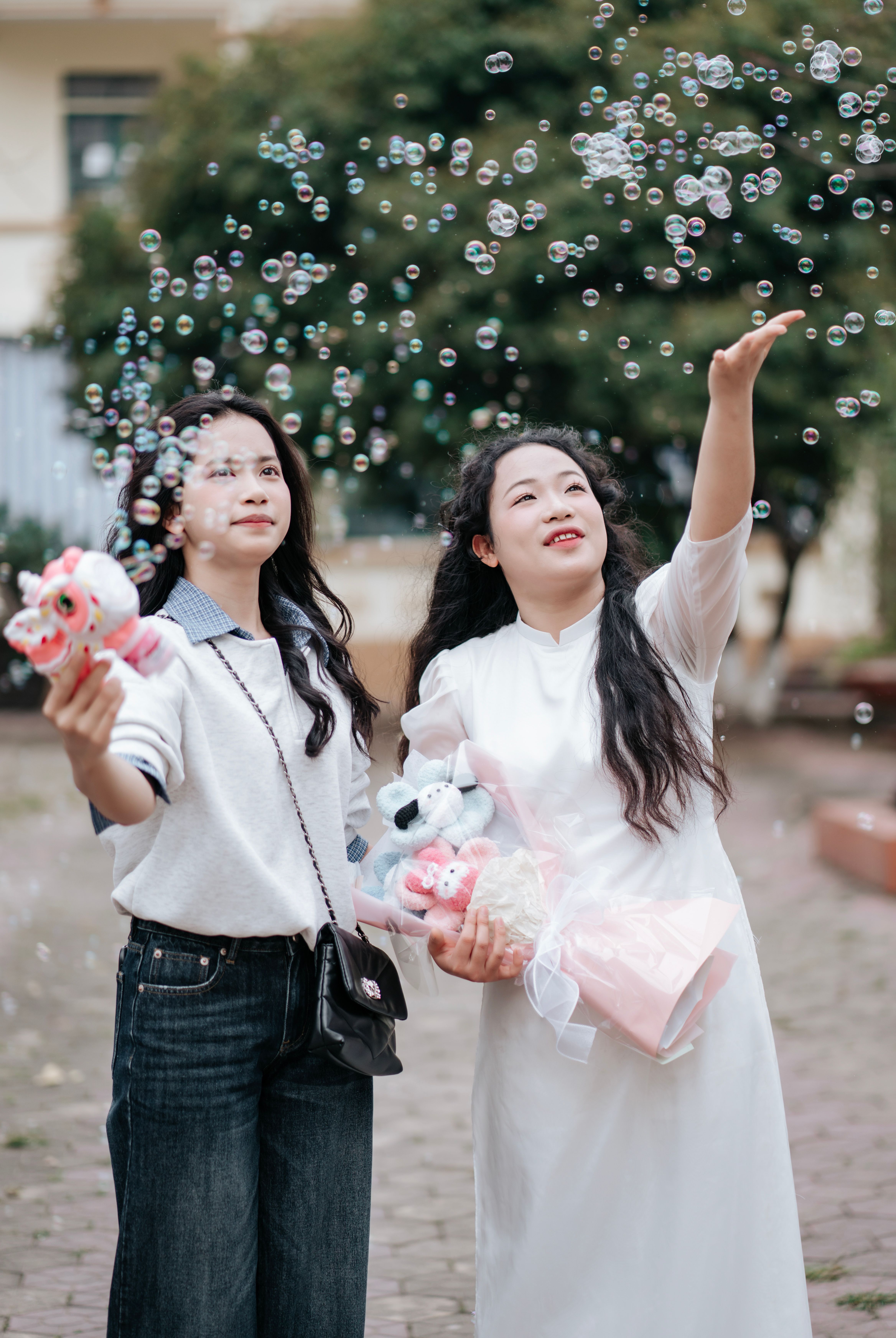Joyful Women Celebrating with Bubbles Outdoors · Free Stock Photo