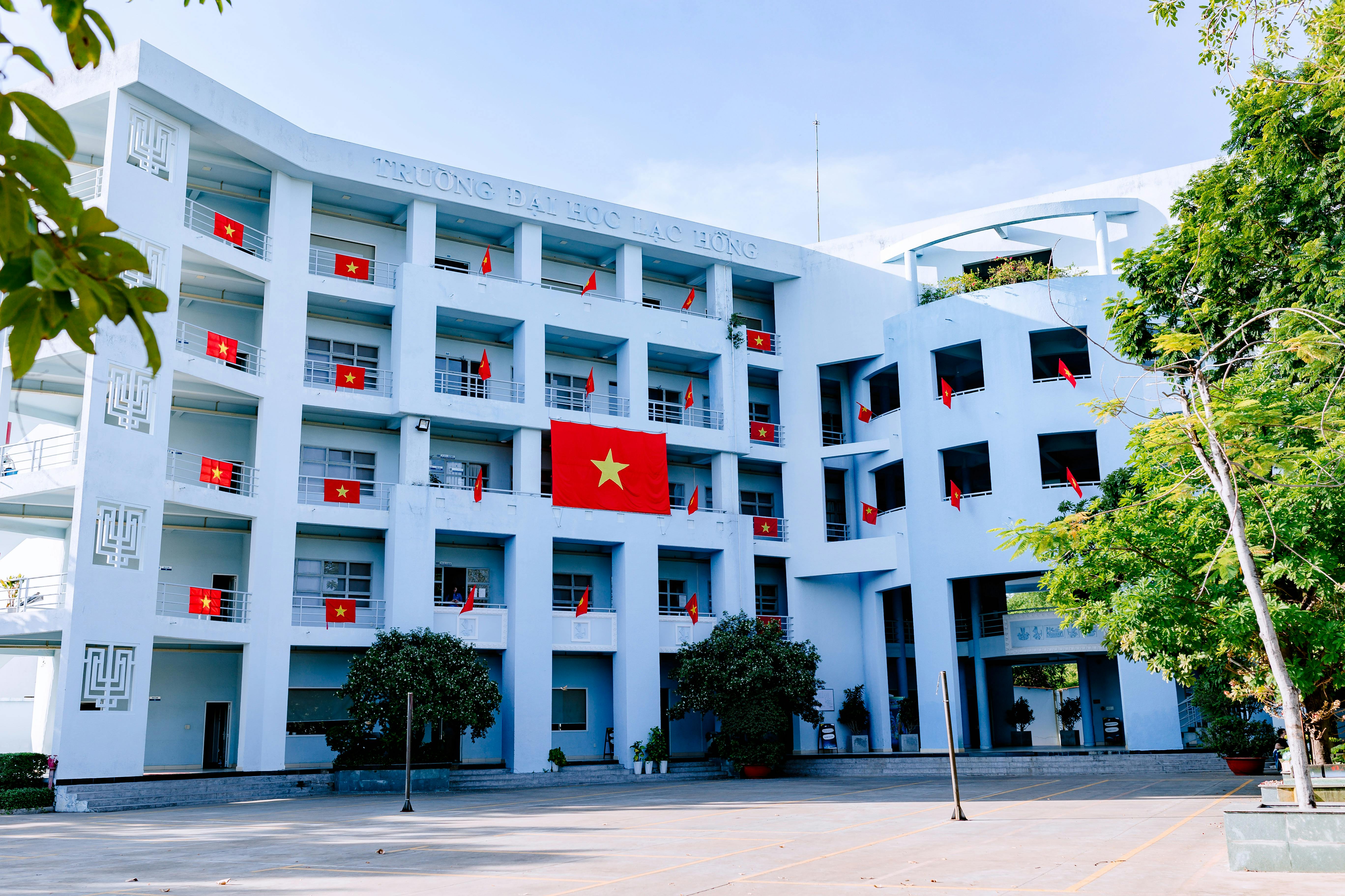 University Building with Vietnamese Flags · Free Stock Photo