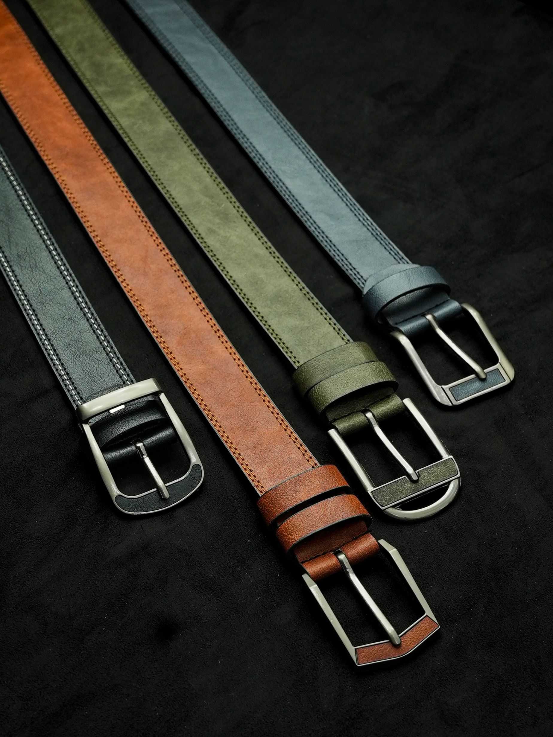 Set of Stylish Leather Belts on Black Surface · Free Stock Photo