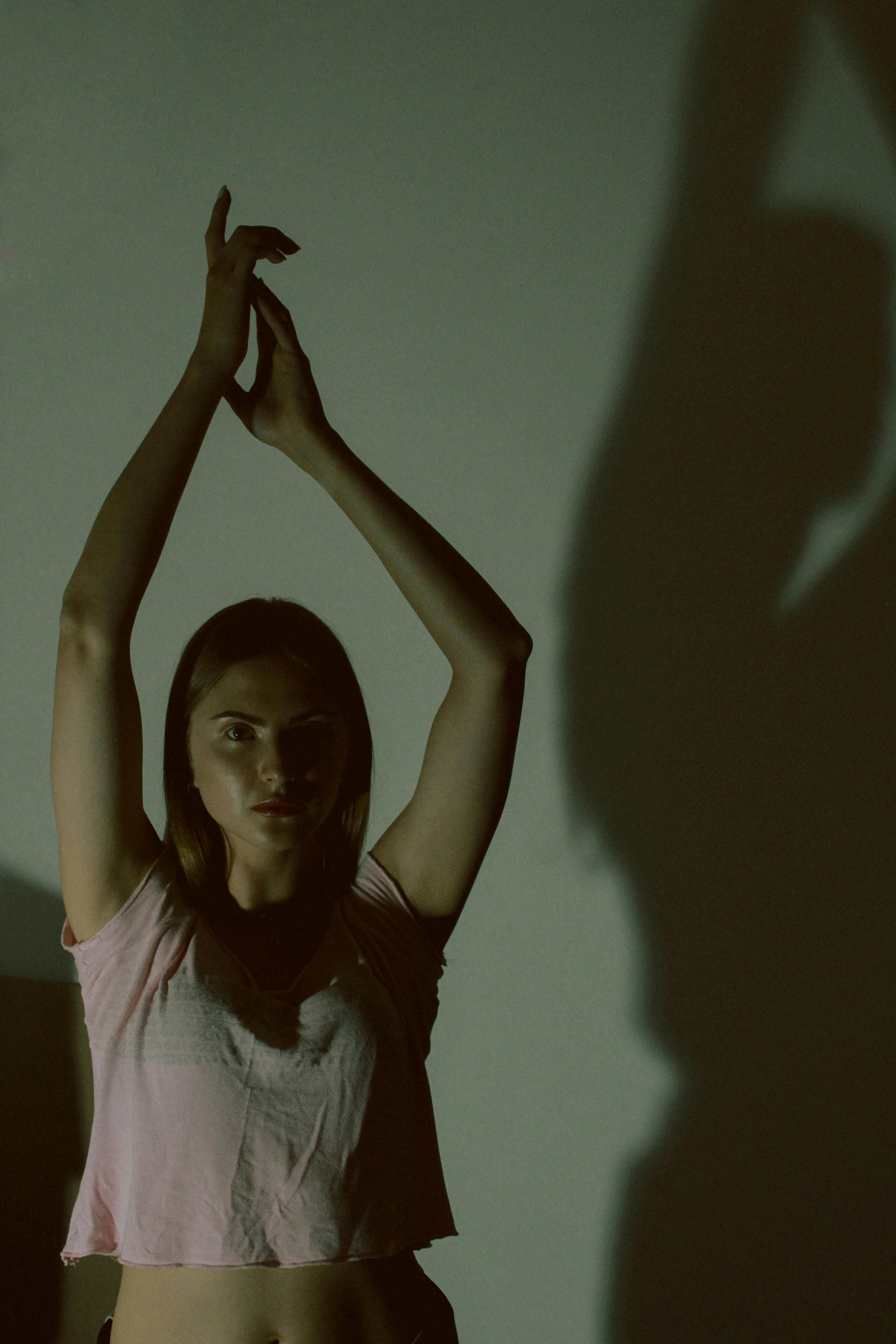 Artistic Shadow Portrait of a Woman with Raised Arms · Free Stock Photo