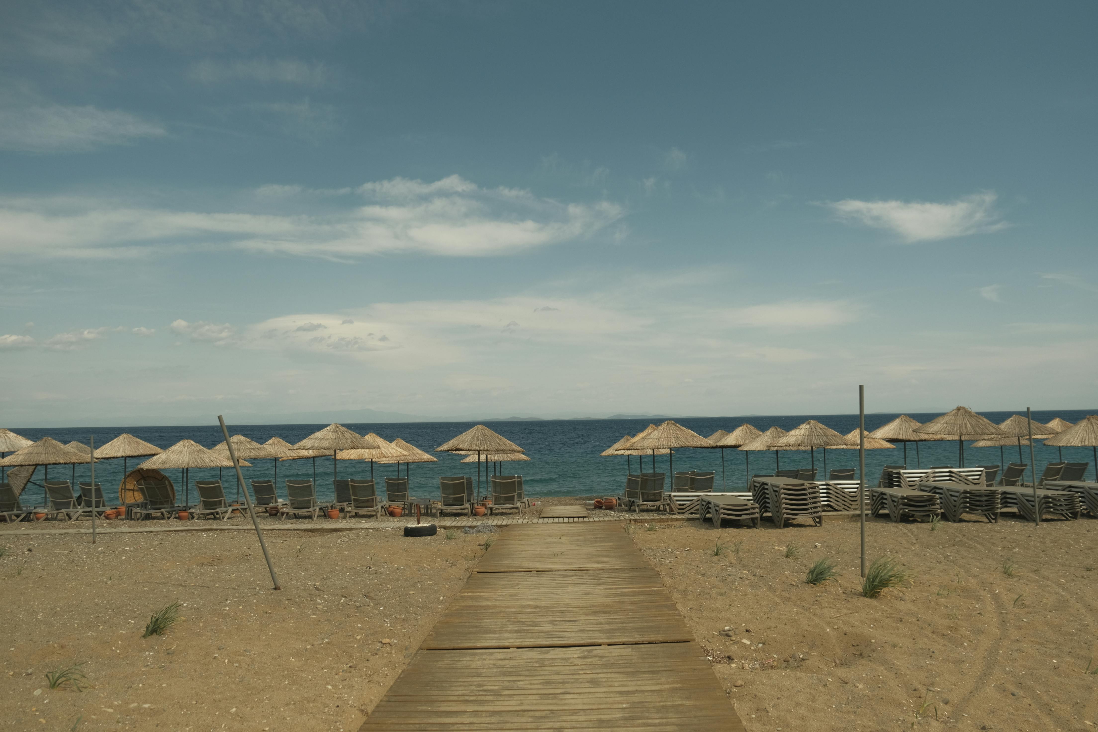 Serene Beachfront View with Umbrellas in Çanakkale · Free Stock Photo