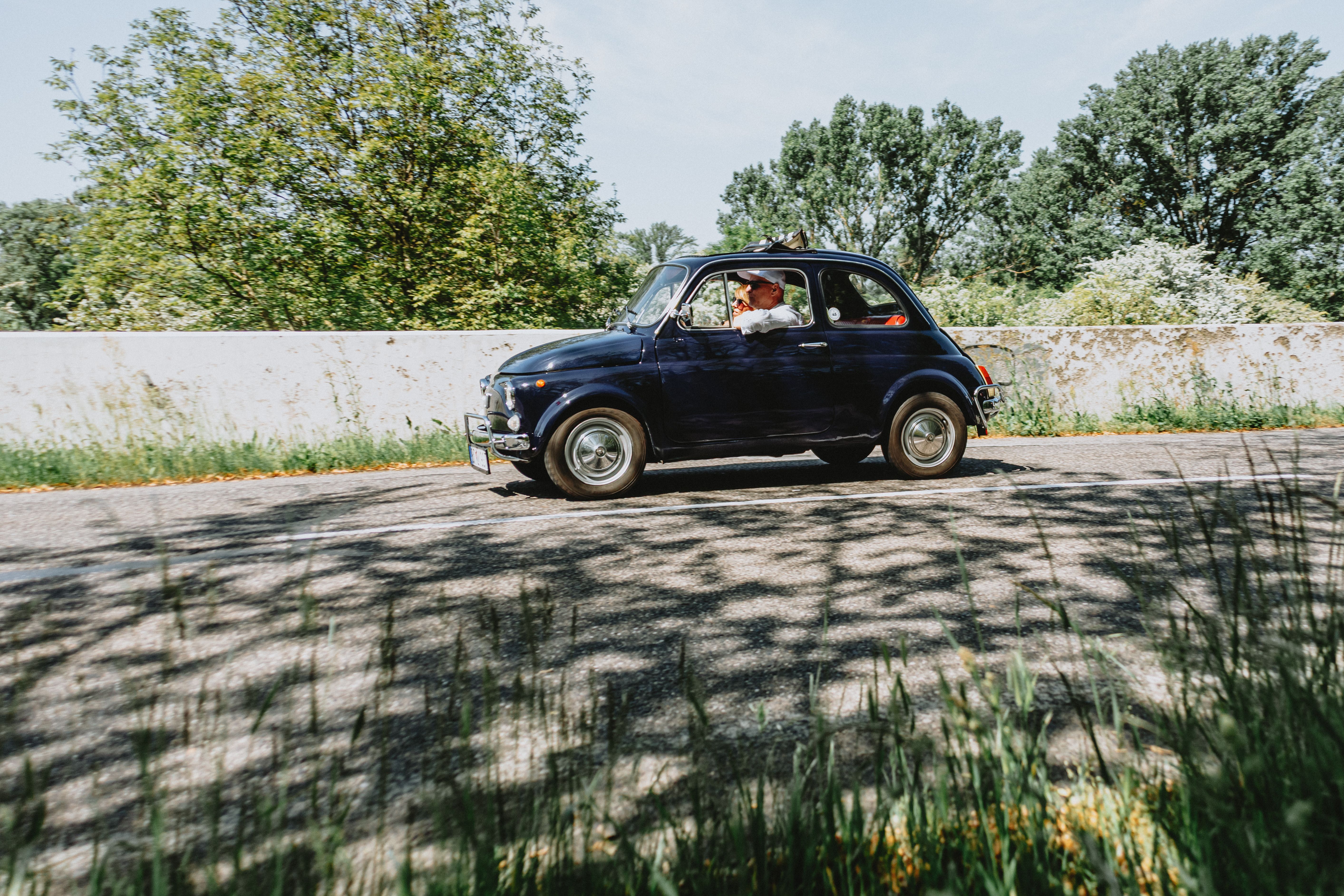 Classic Fiat Car Driving on a Sunny Road · Free Stock Photo