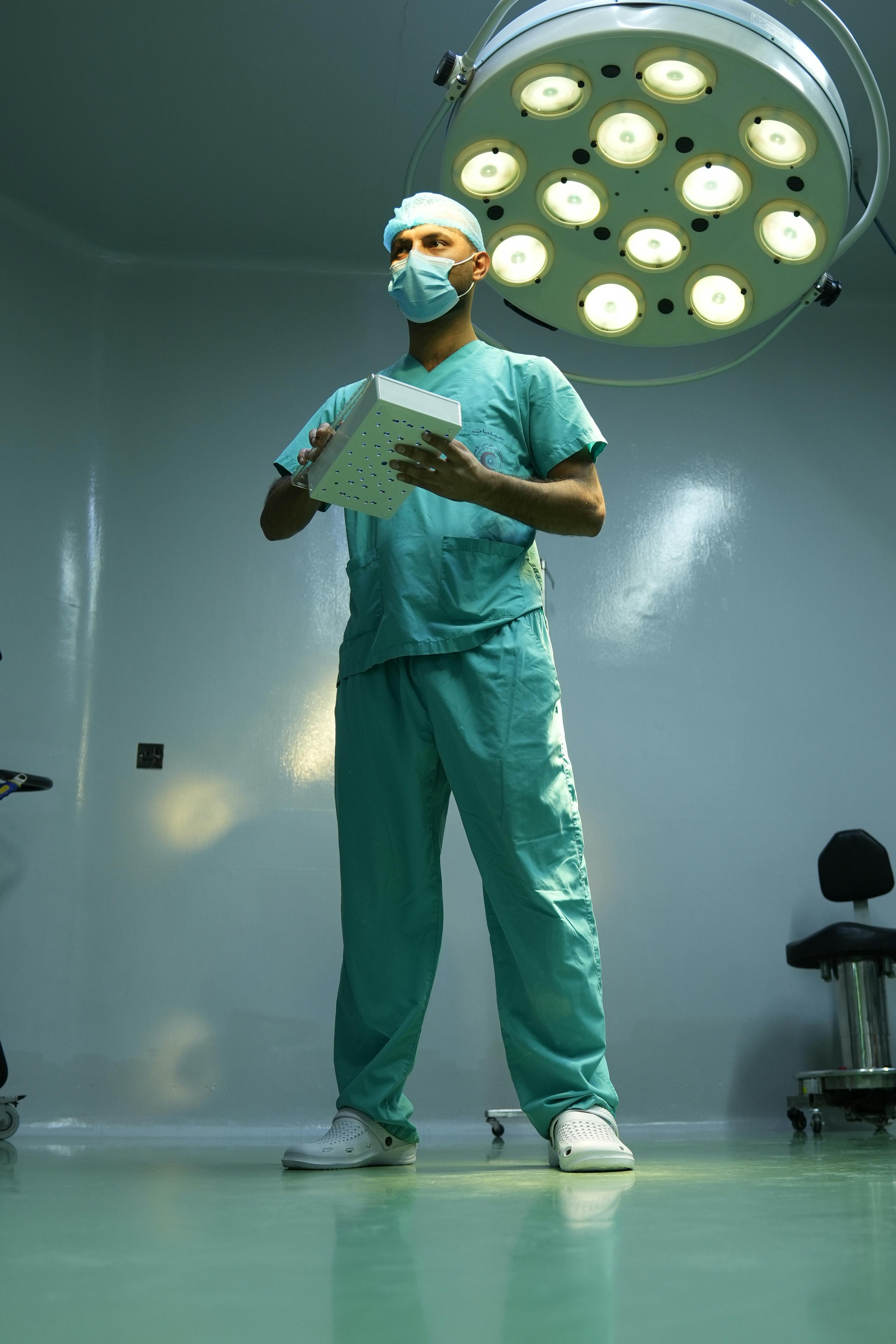 Surgeon in an Operating Room Under Surgical Lights · Free Stock Photo