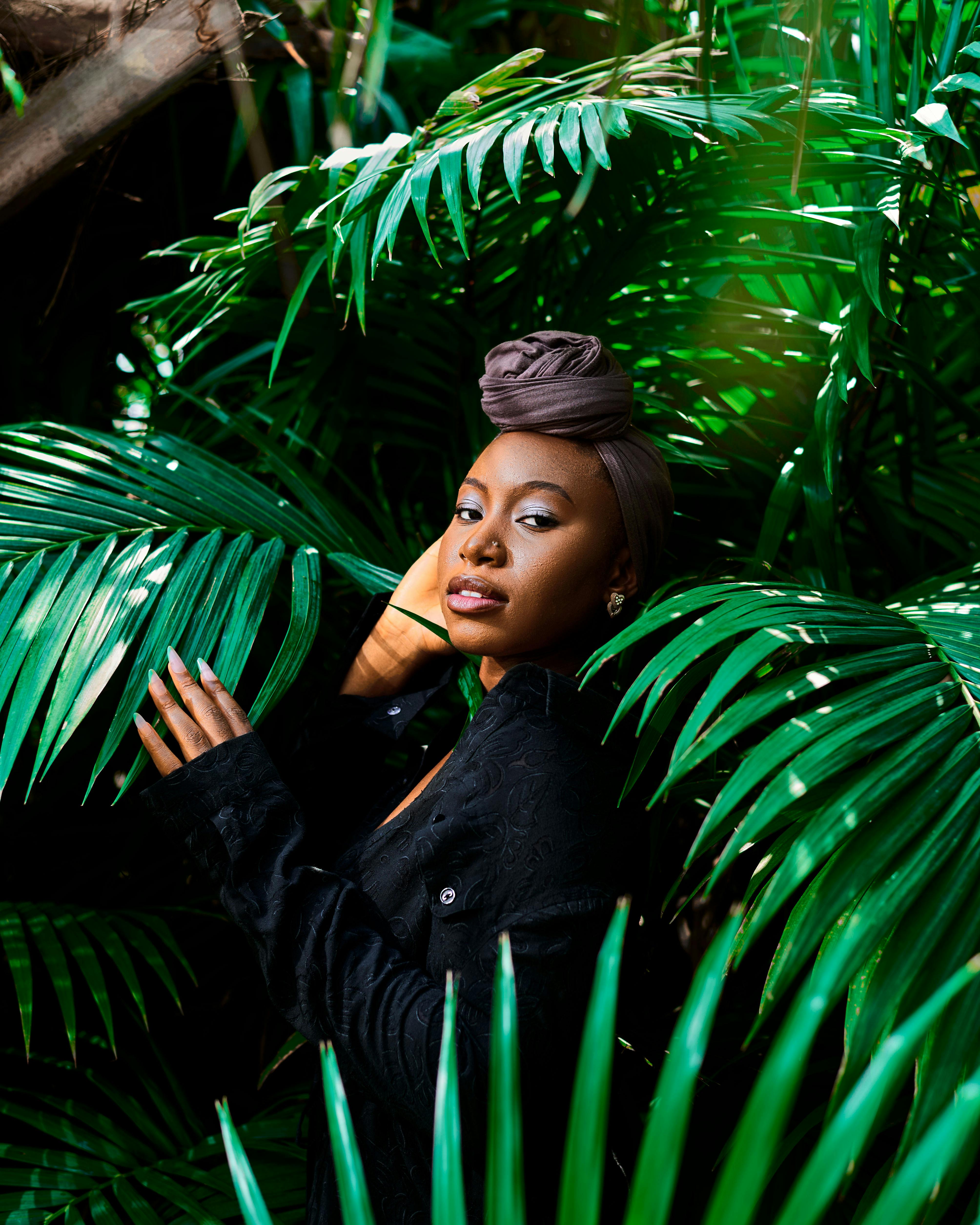 Elegant Woman Amidst Lush Greenery Portrait · Free Stock Photo