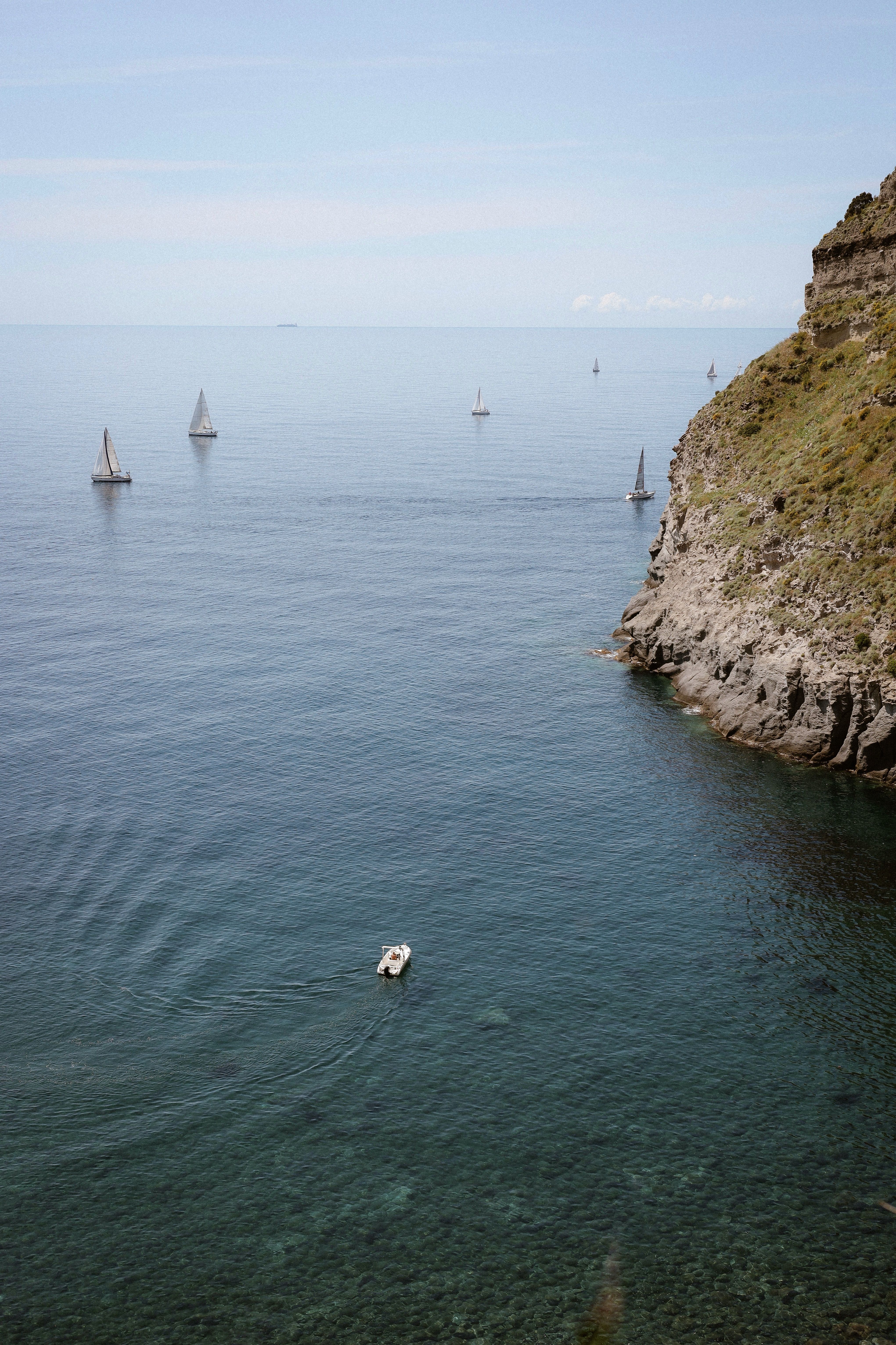 Sailboats and Cliffside View in Serene Ocean Scene · Free Stock Photo