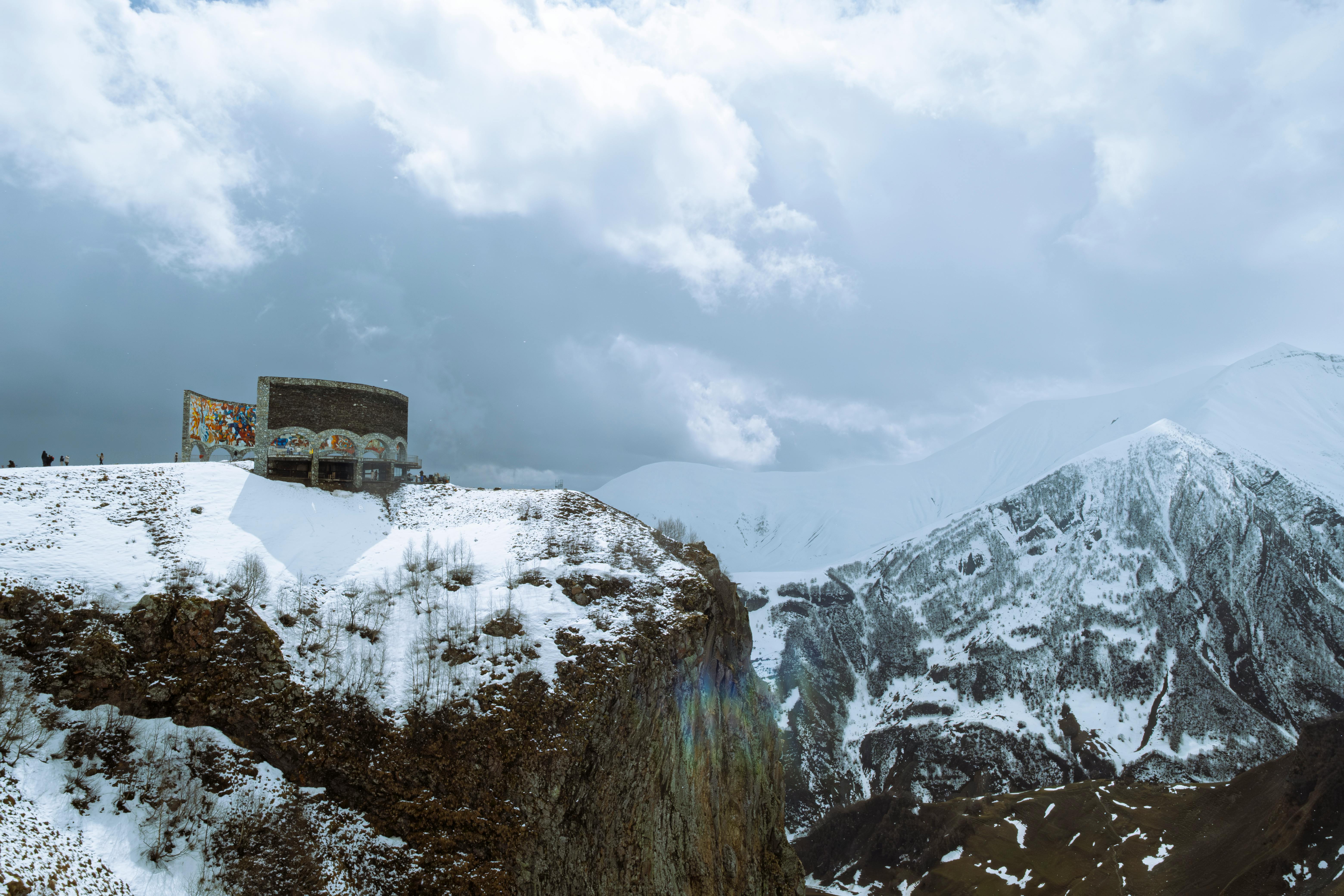 Snow-Covered Cliffs and Monument in Georgia · Free Stock Photo