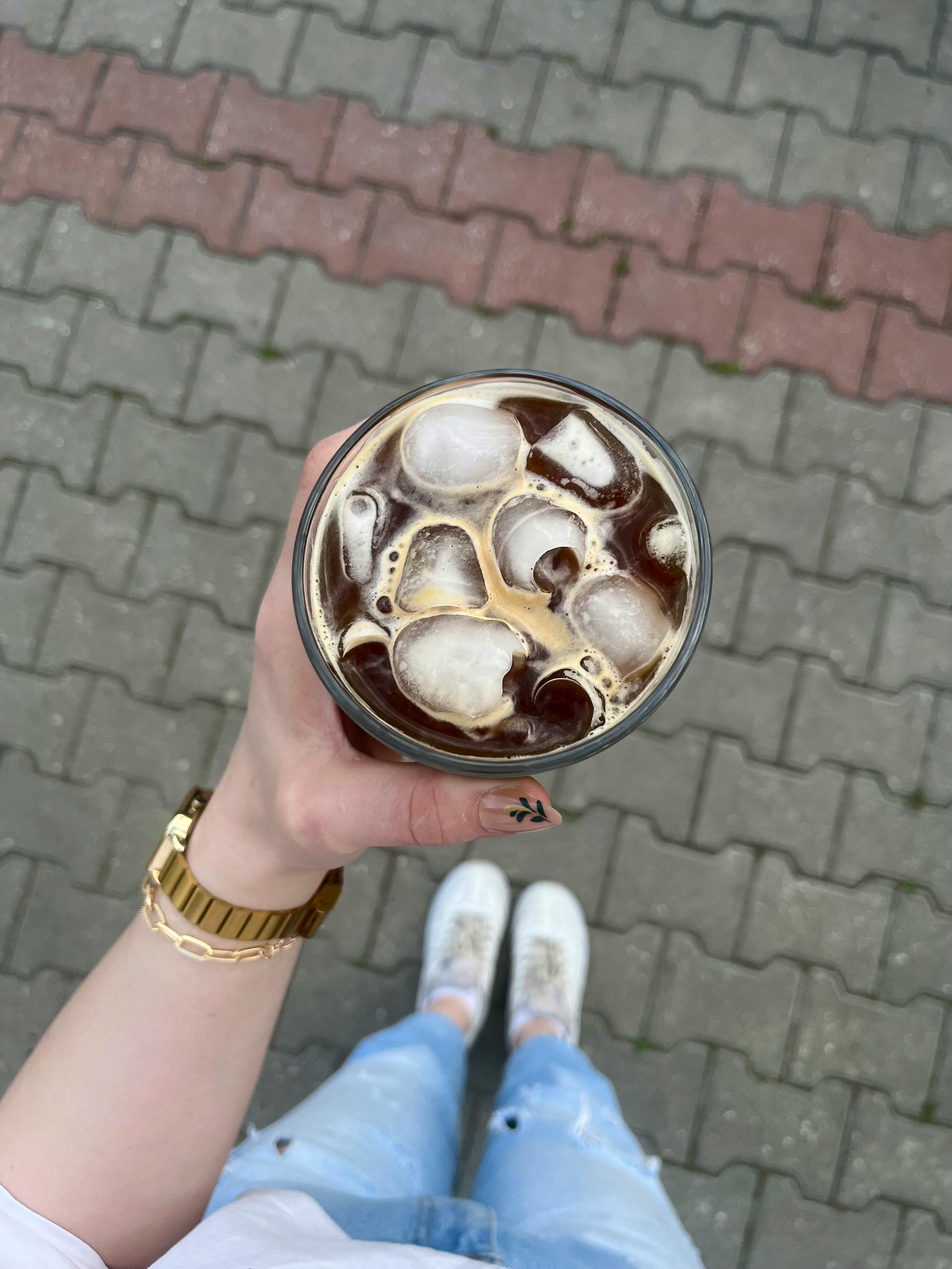 Top View of Iced Coffee in Hands Outdoors · Free Stock Photo