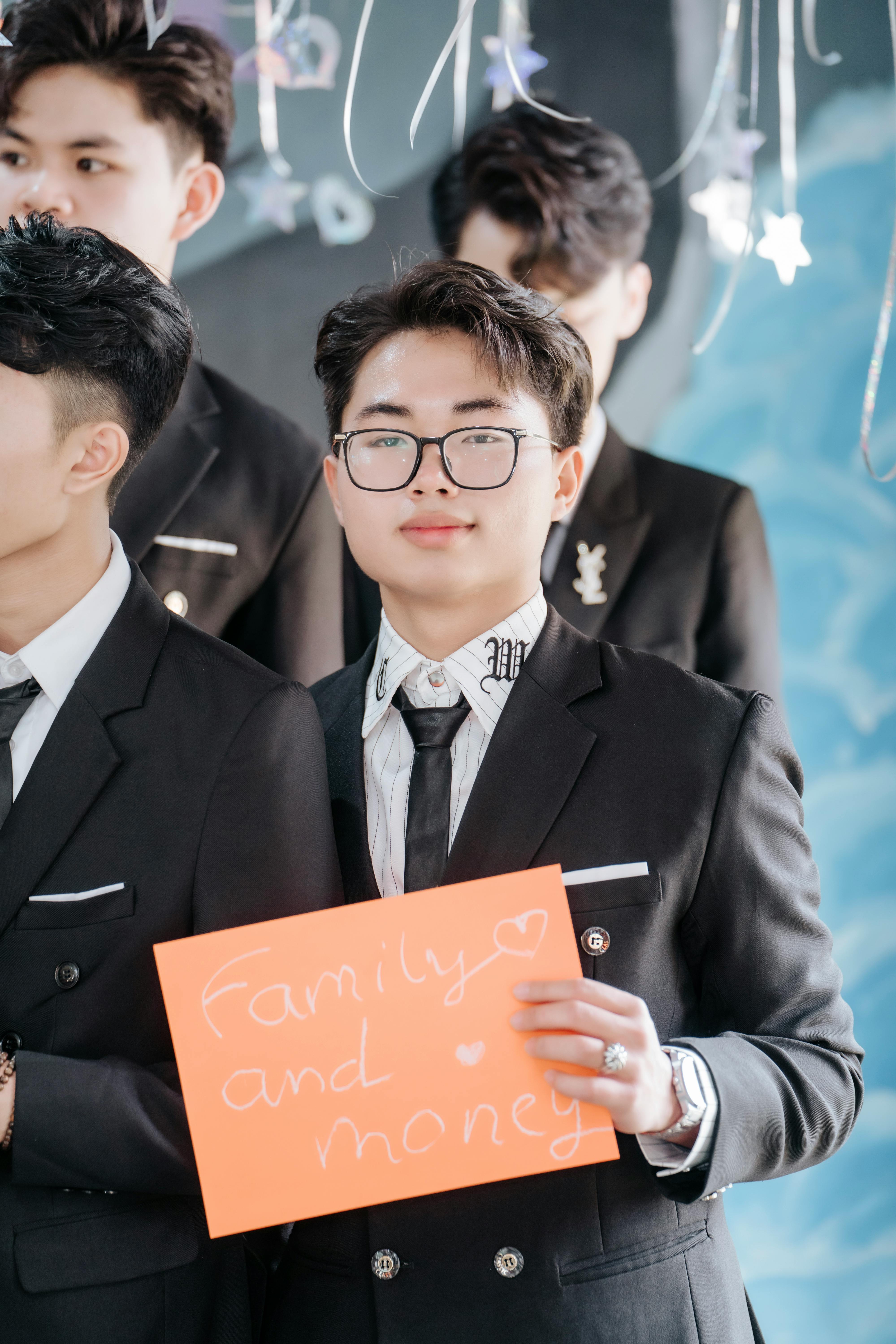 Young Adults with Message Sign in Formal Attire · Free Stock Photo