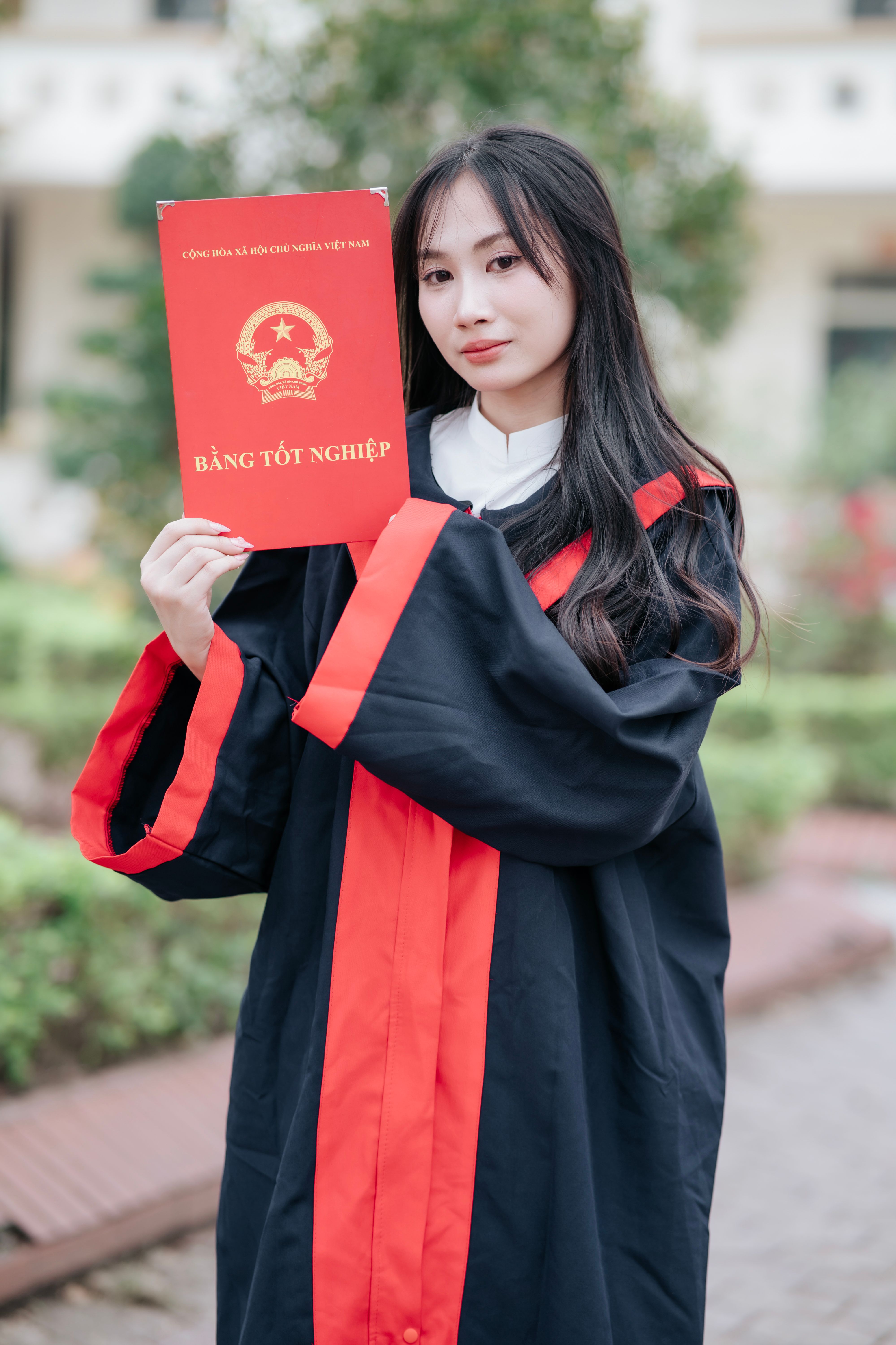 Woman Wearing Black Graduation Coat Sits on Stairs · Free Stock Photo