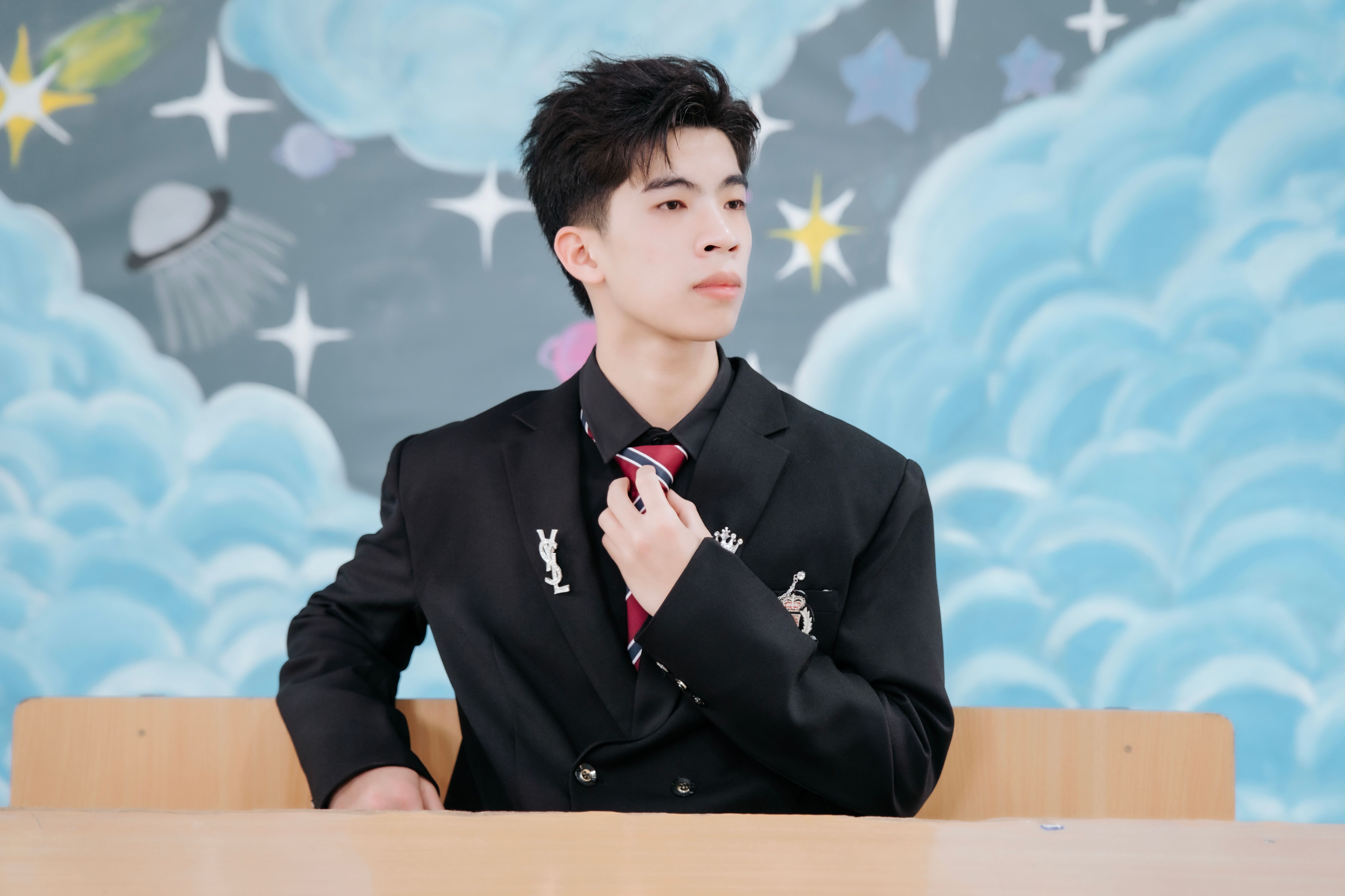 Young Man in Suit with Dreamy Cloud Mural · Free Stock Photo