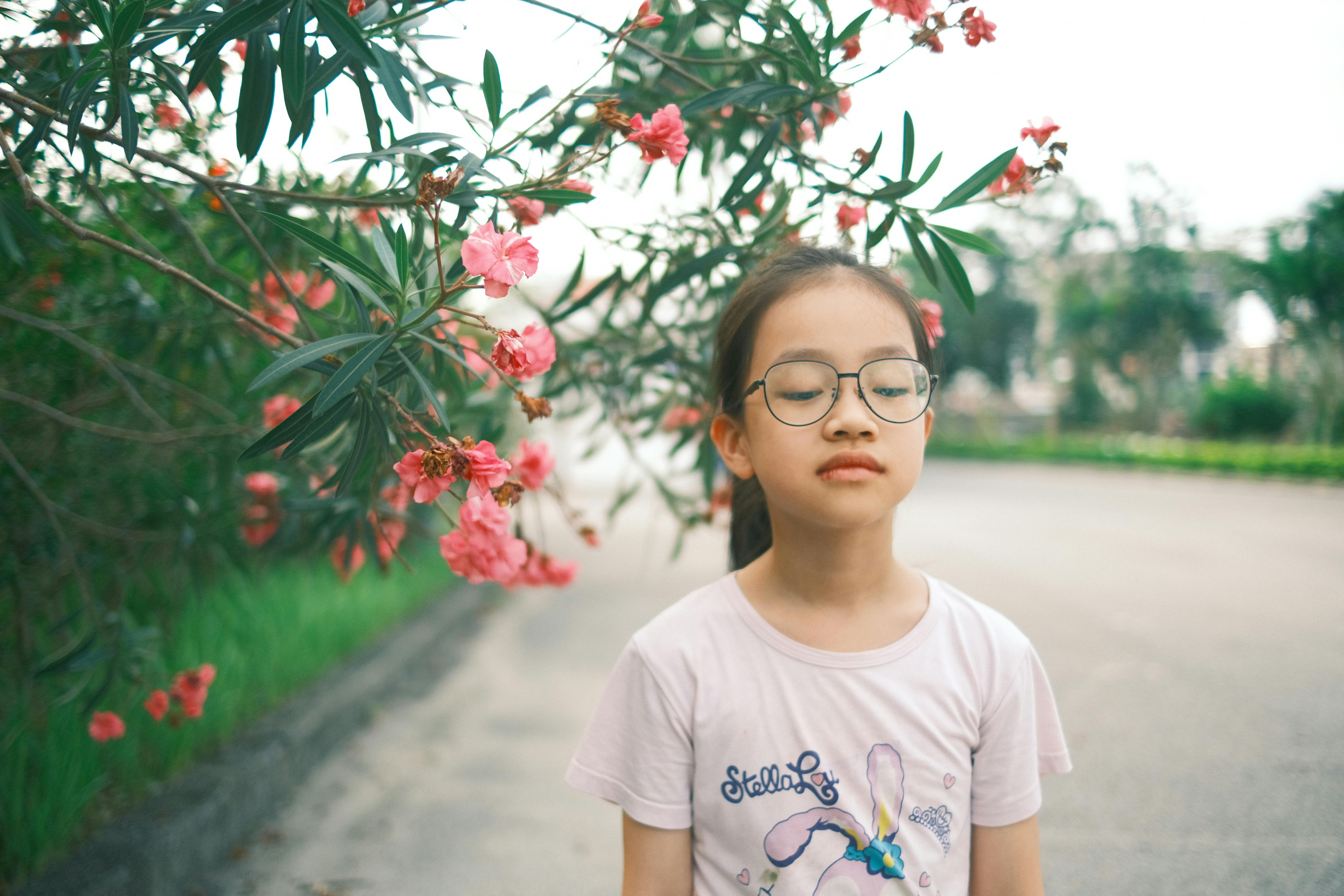 Young Girl with Glasses Near Blooming Flower · Free Stock Photo