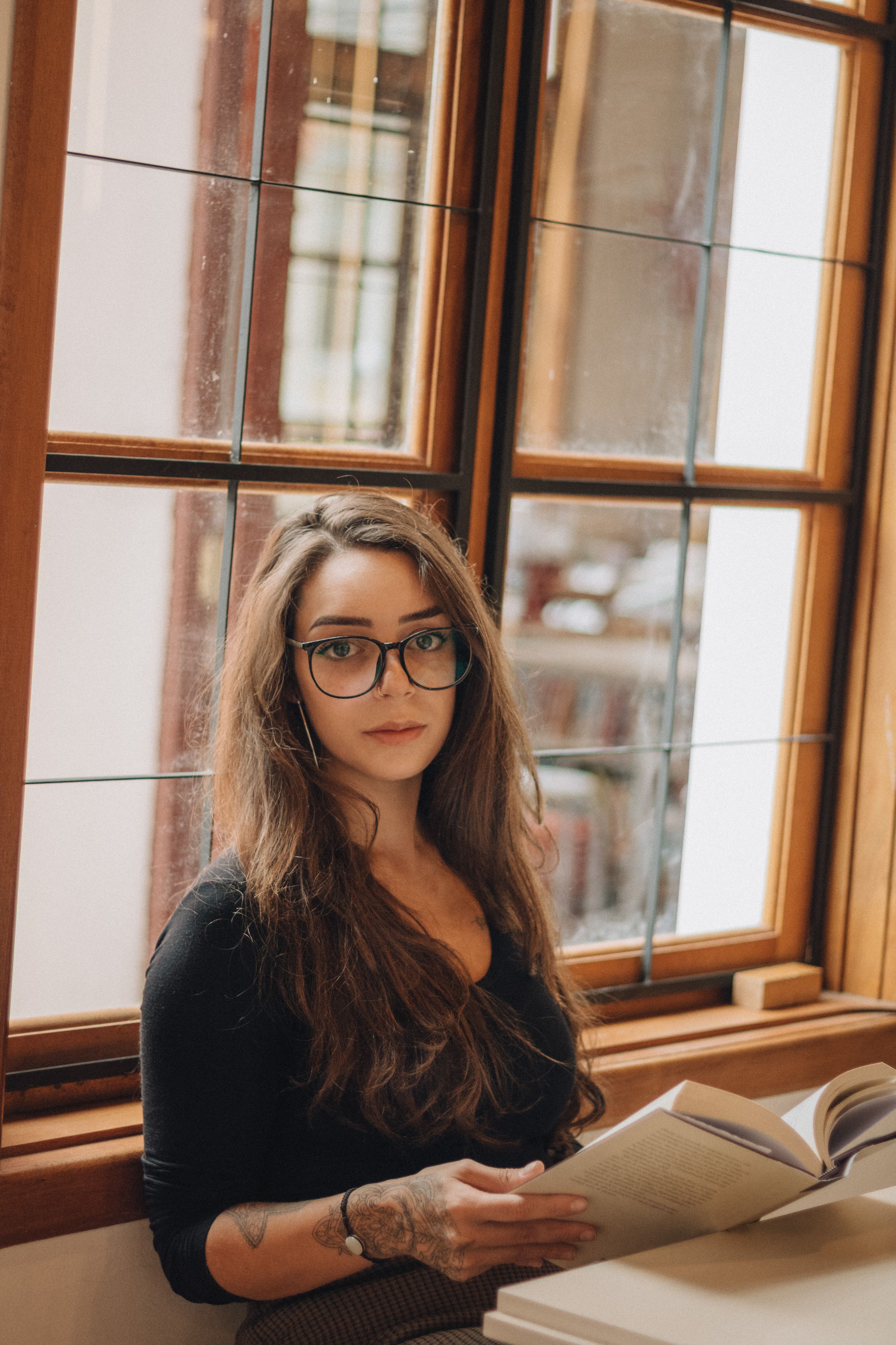 Young woman reading by a window indoors · Free Stock Photo
