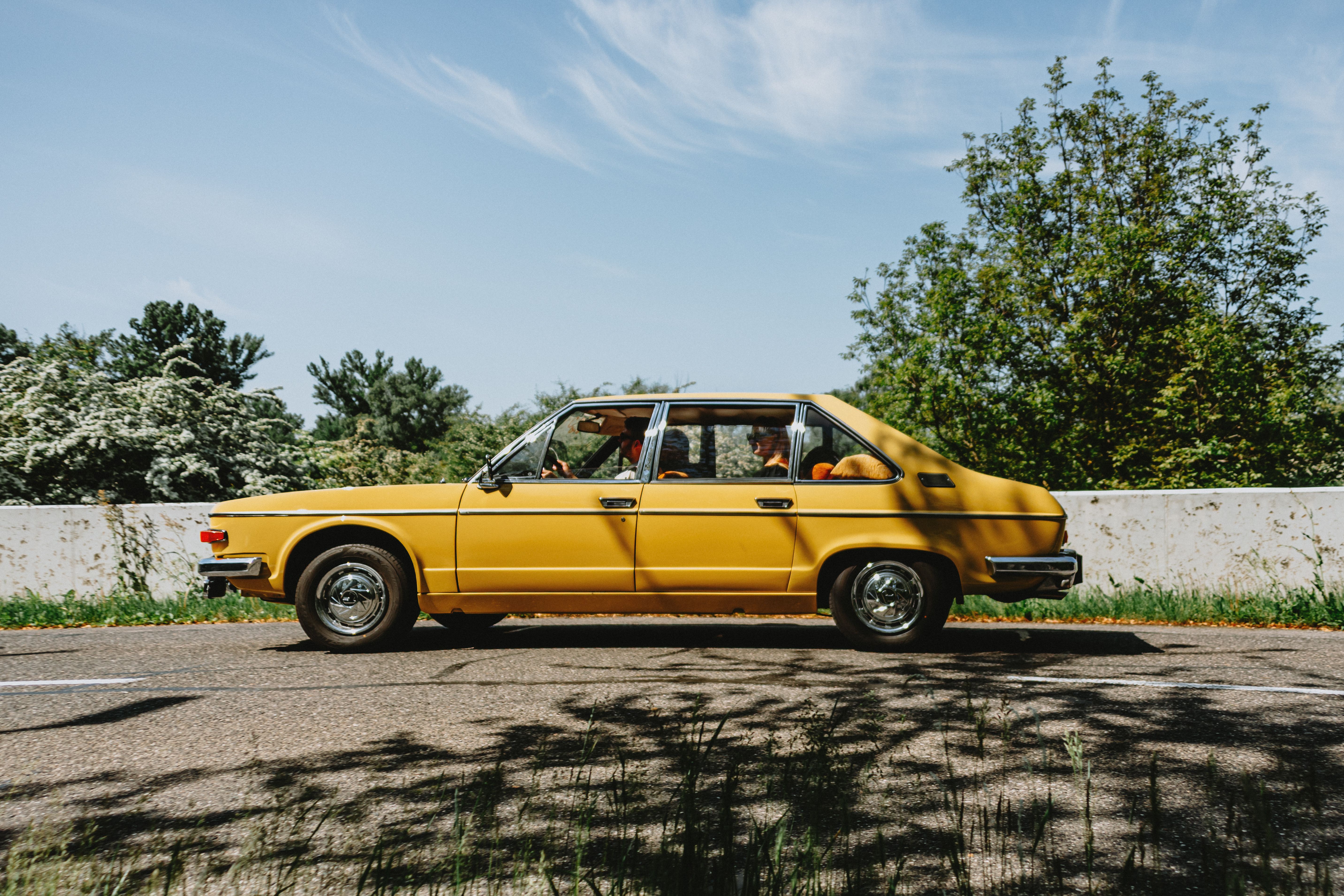 Vintage Yellow Car on Scenic Roadside Drive · Free Stock Photo