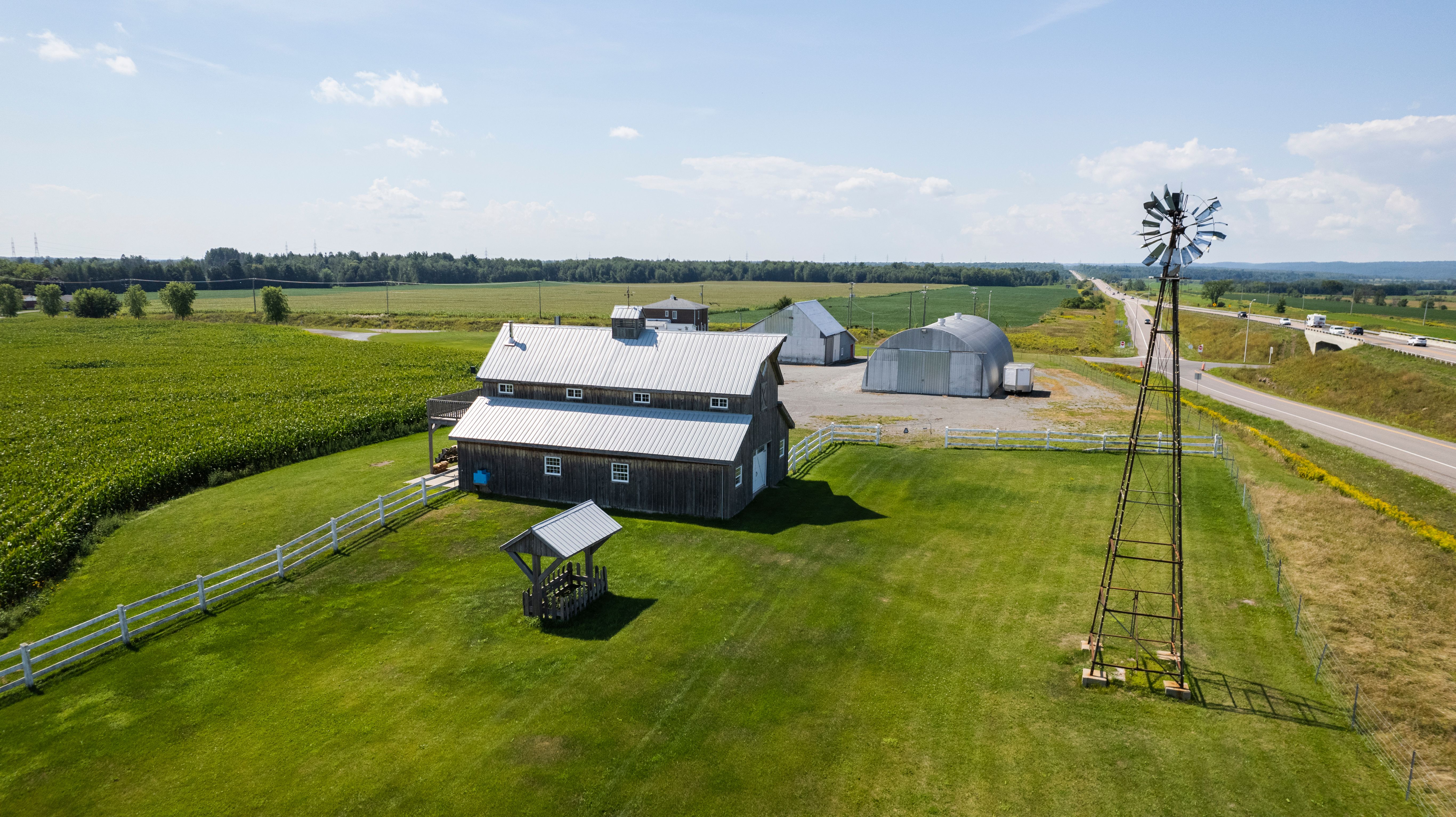 Rustic Farmhouse and Windmill in Québec Countryside · Free Stock Photo