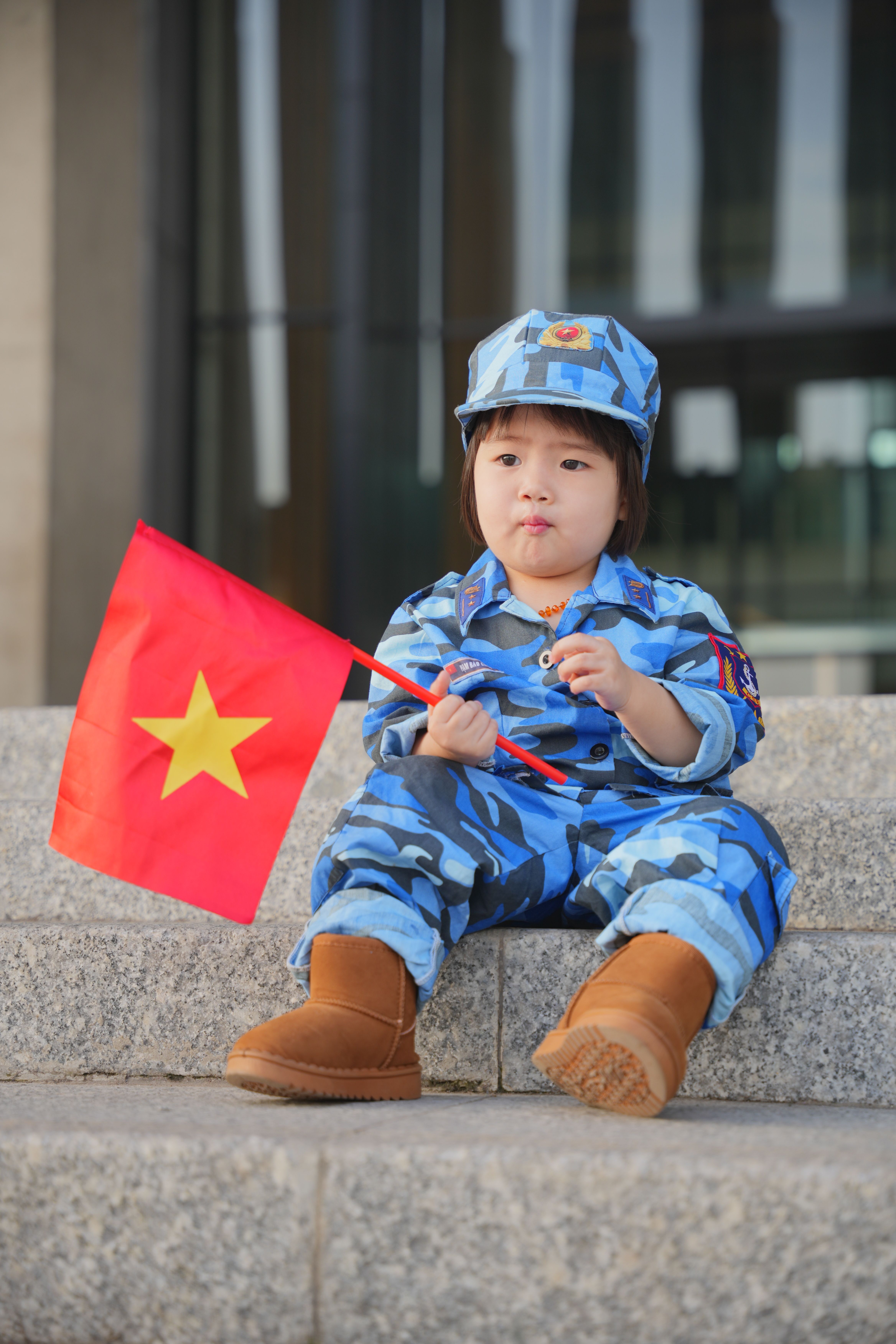 Child in Military Uniform Holding Vietnam Flag · Free Stock Photo