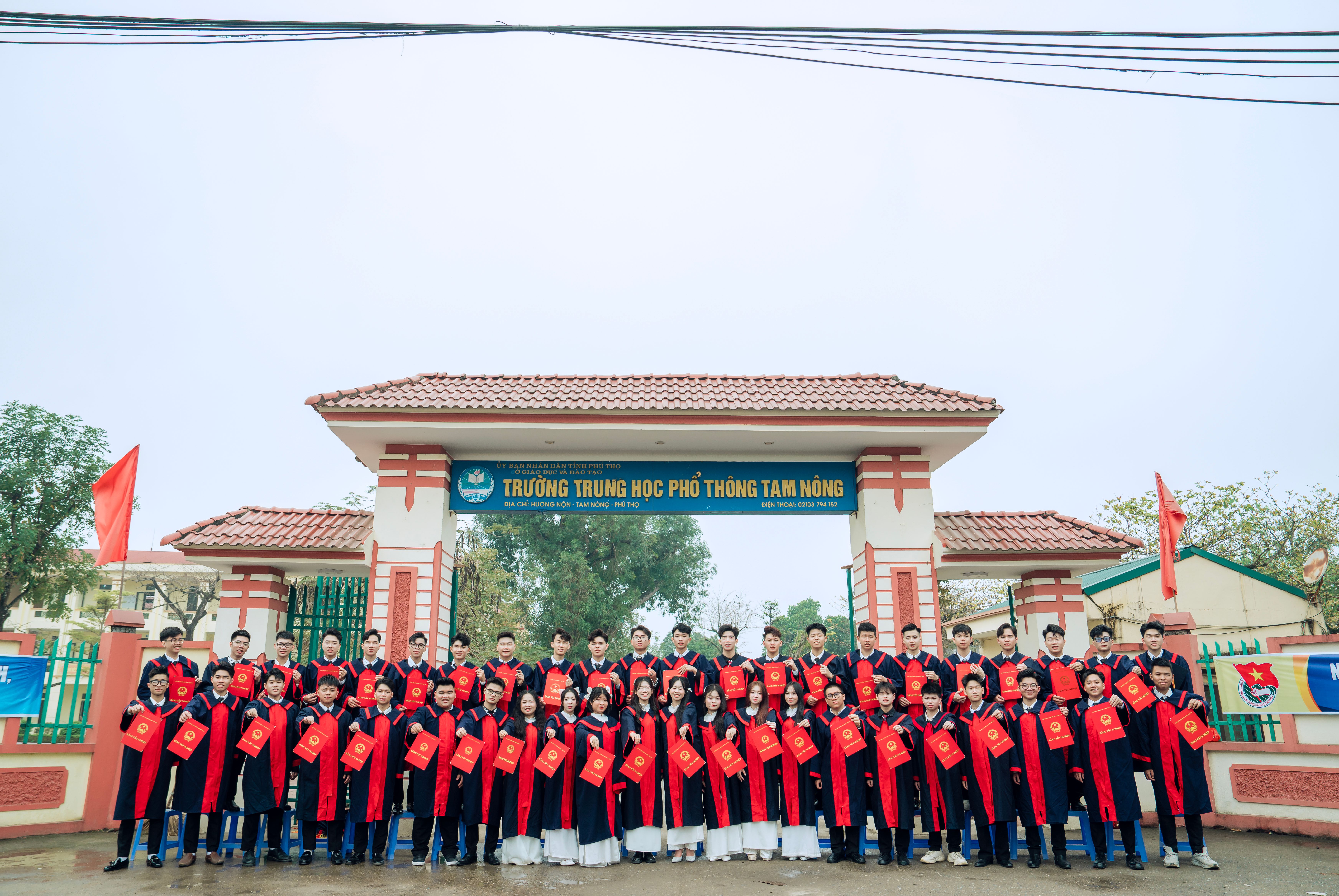 Group of Students in Graduation Robes at School Gate · Free Stock Photo