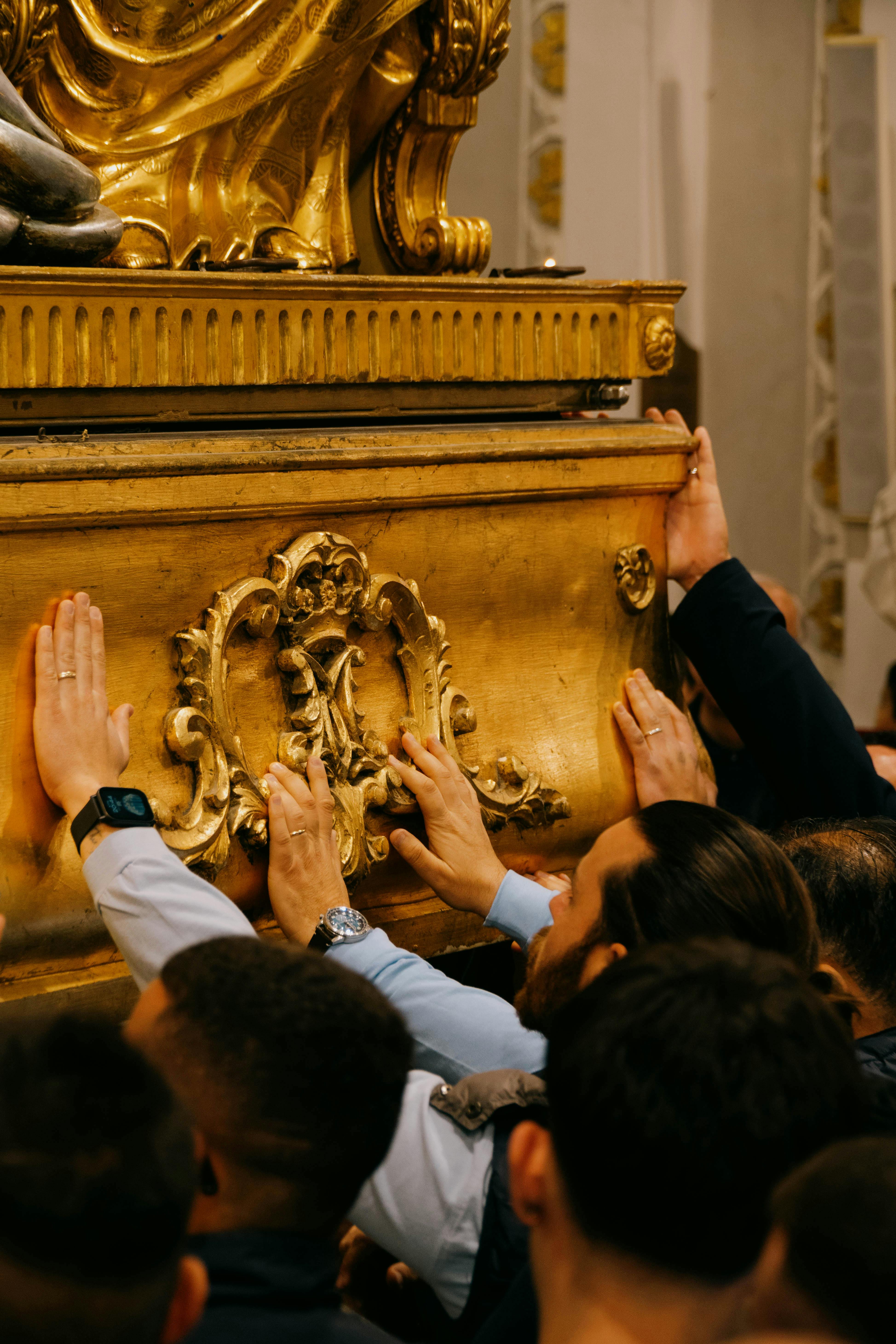 Group of People Touching Gold Religious Artifact · Free Stock Photo