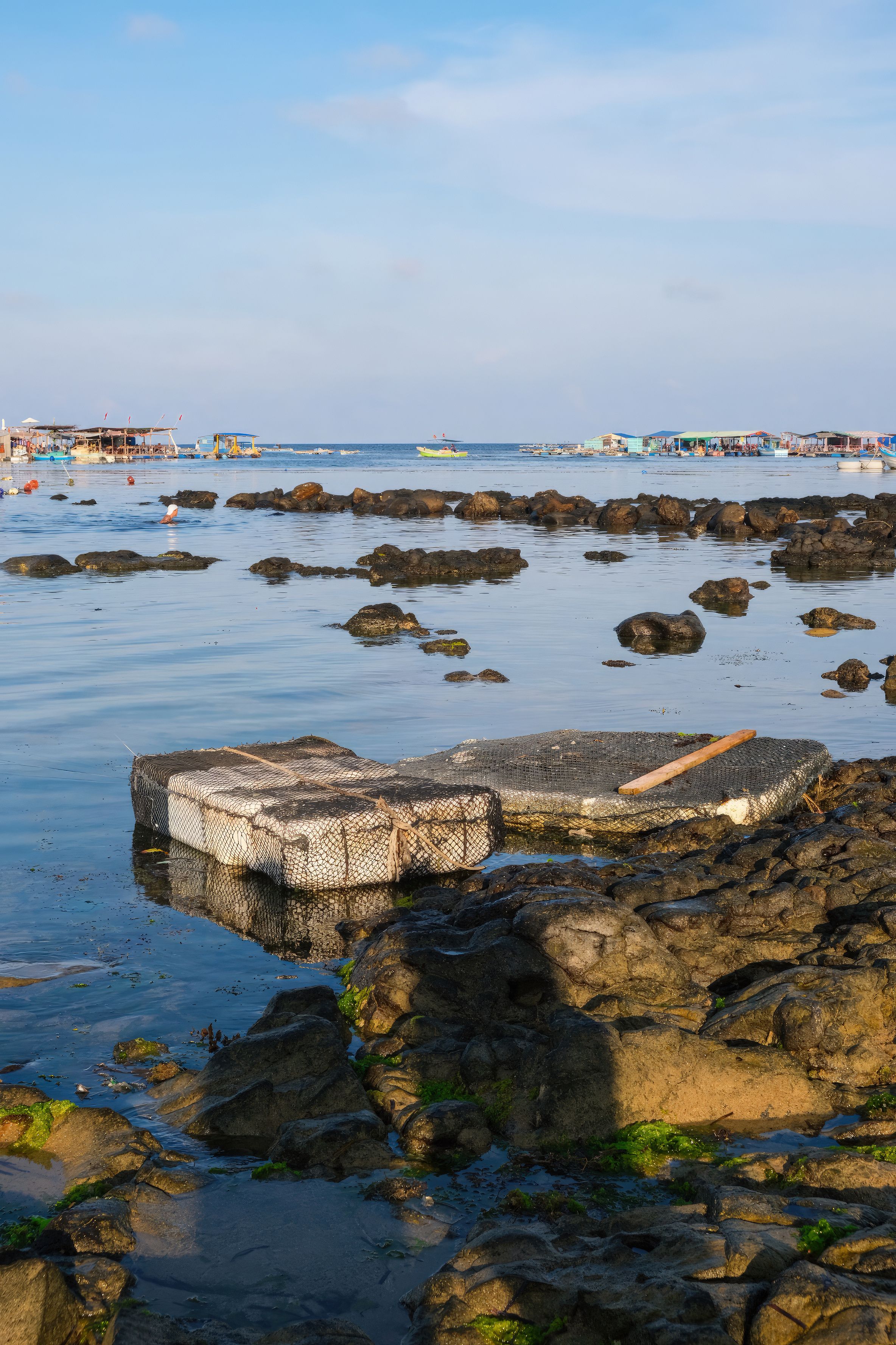 Scenic Rocky Shoreline with Floating Village · Free Stock Photo