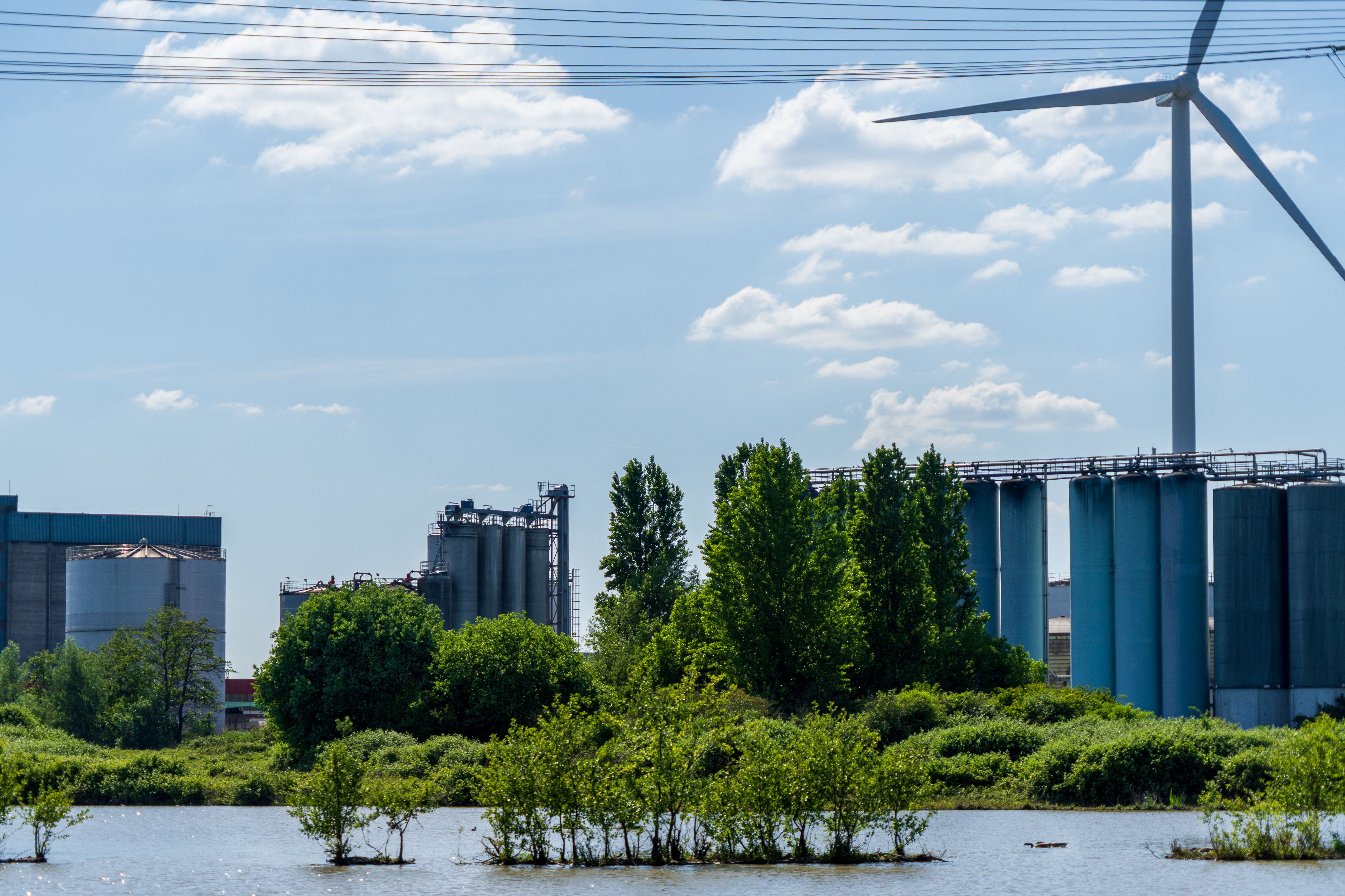 Industrial Landscape with Wind Turbine and Water · Free Stock Photo