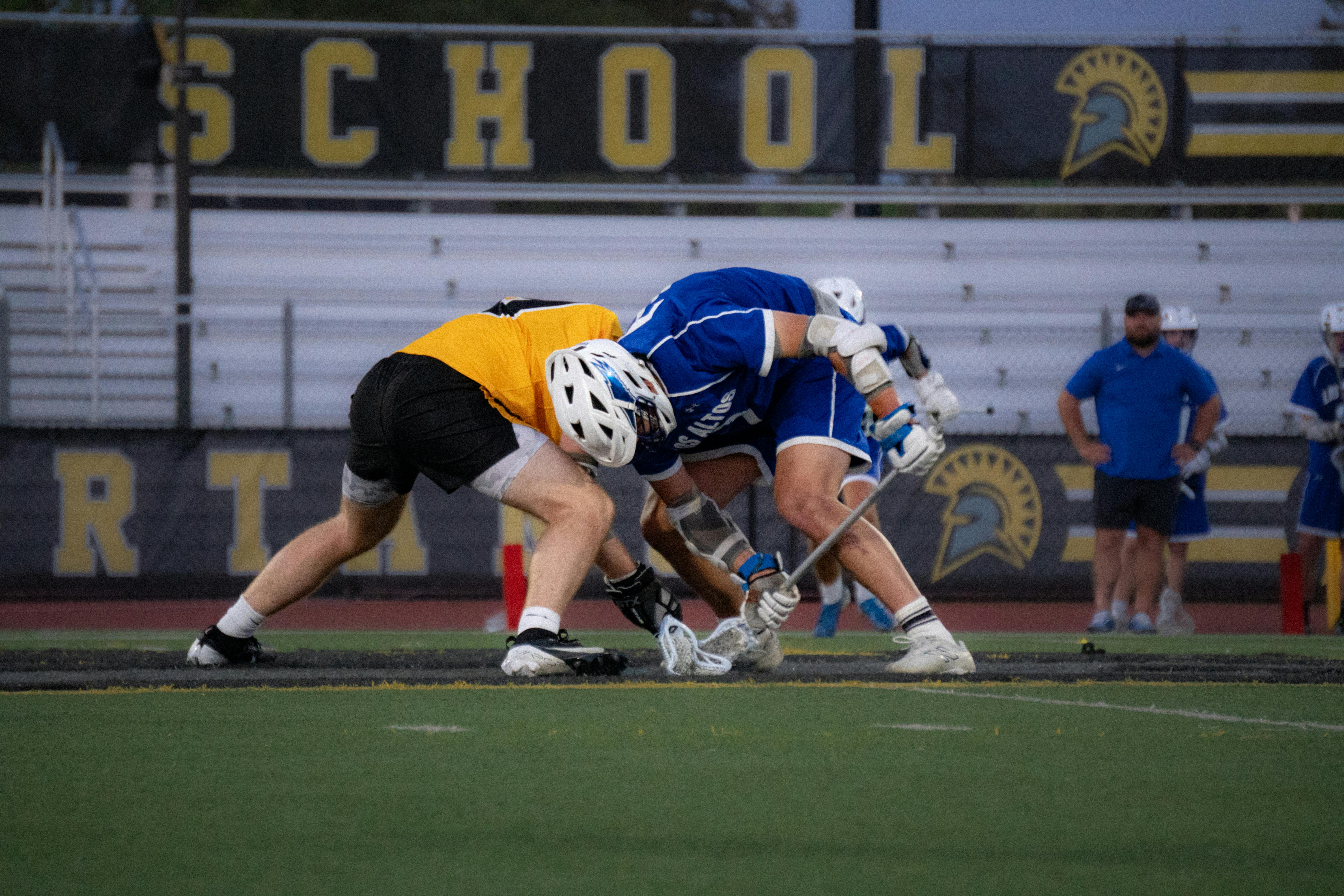 Intense High School Lacrosse Match Faceoff · Free Stock Photo
