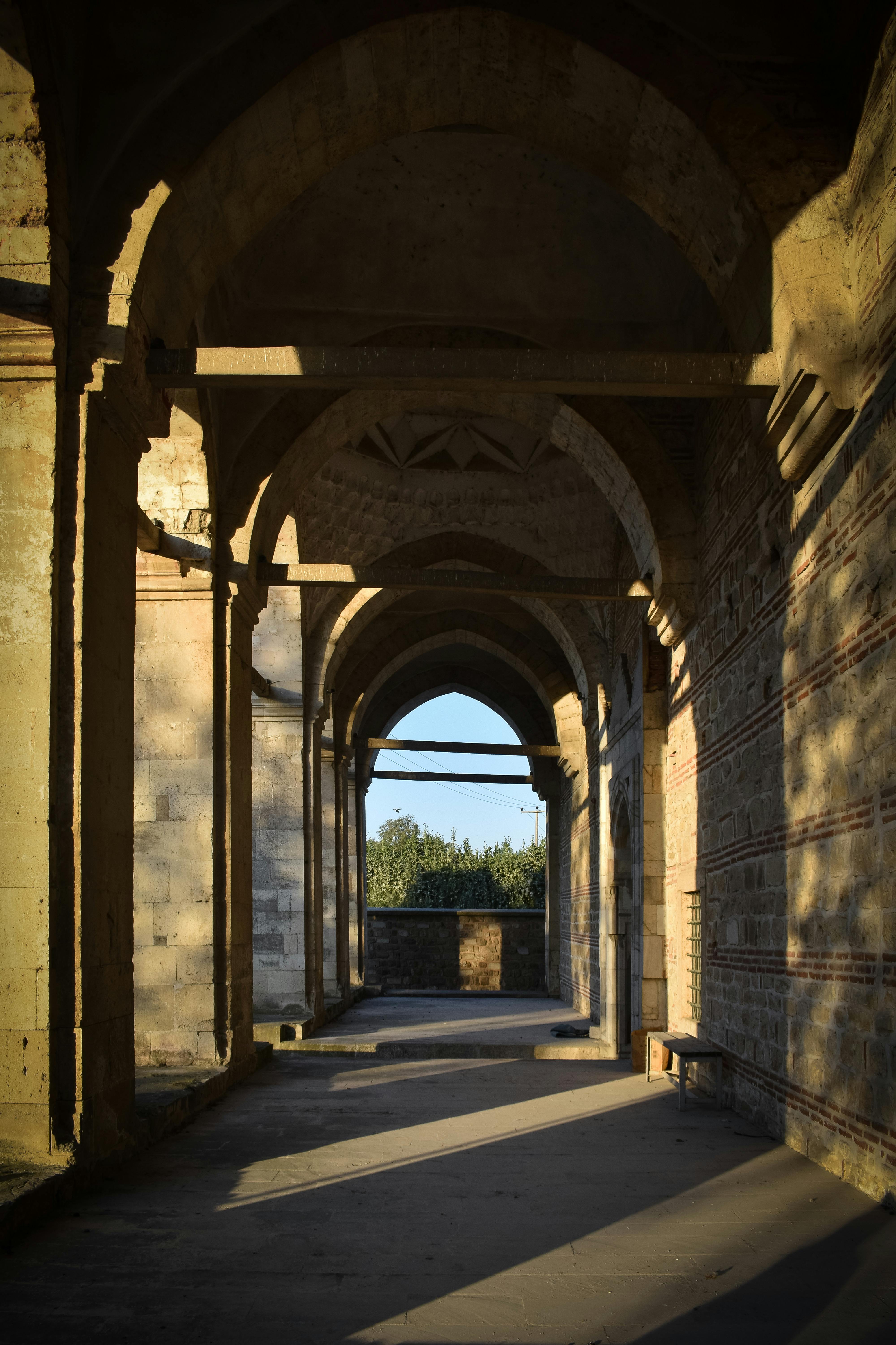 Historic Stone Arch Corridor with Sunlight · Free Stock Photo