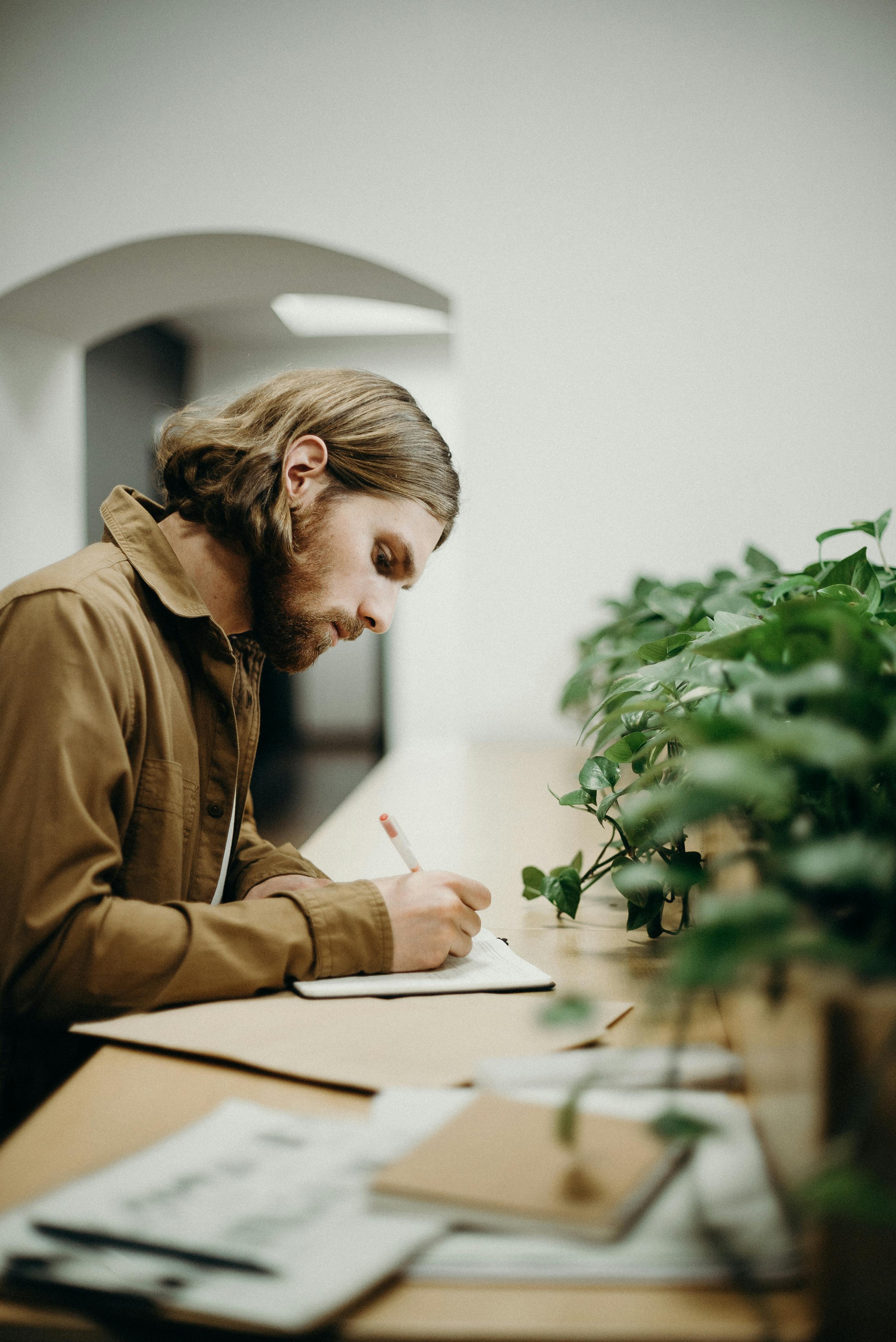 Man Writing on Paper · Free Stock Photo