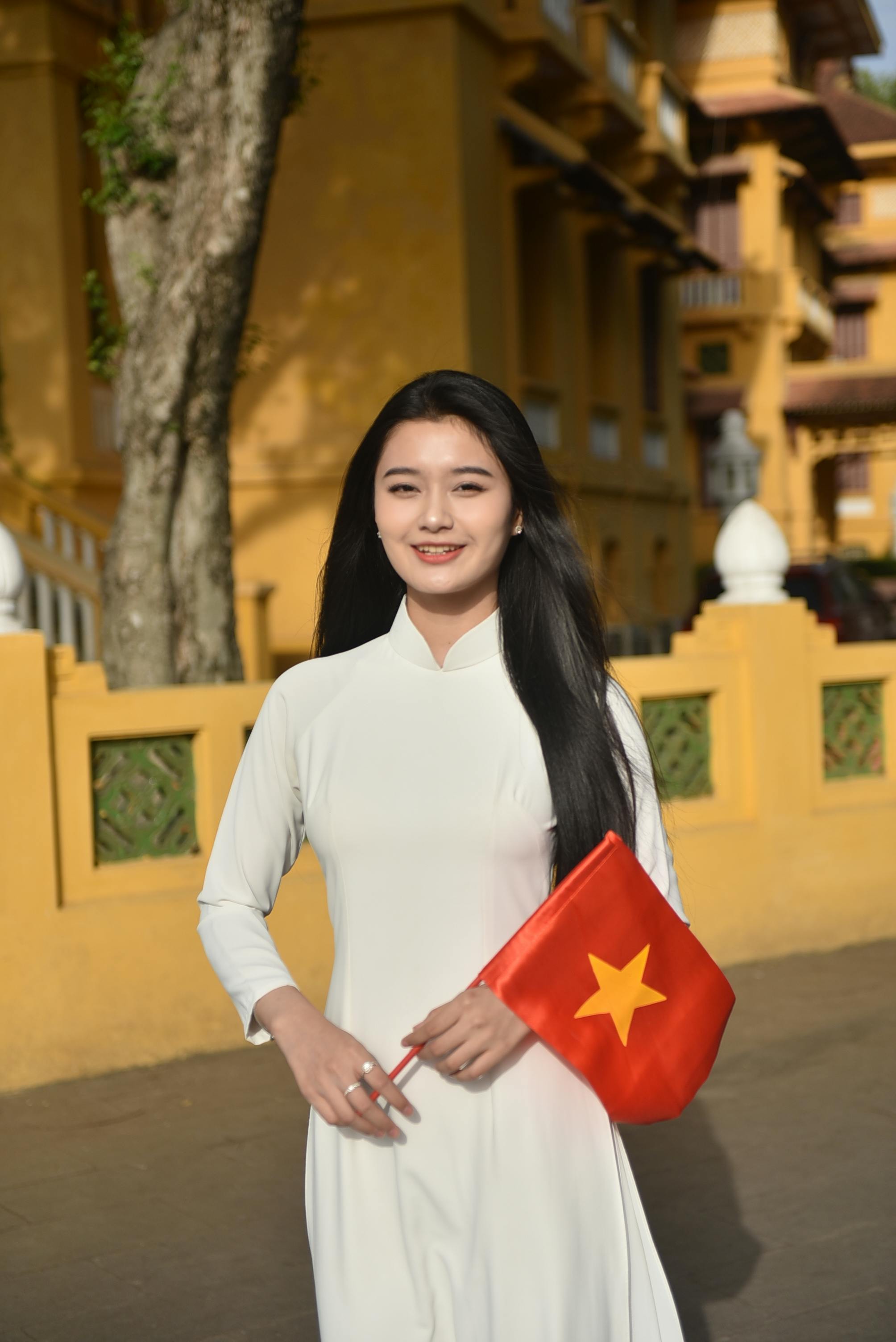 Woman in White Ao Dai Holding Vietnamese Flag · Free Stock Photo