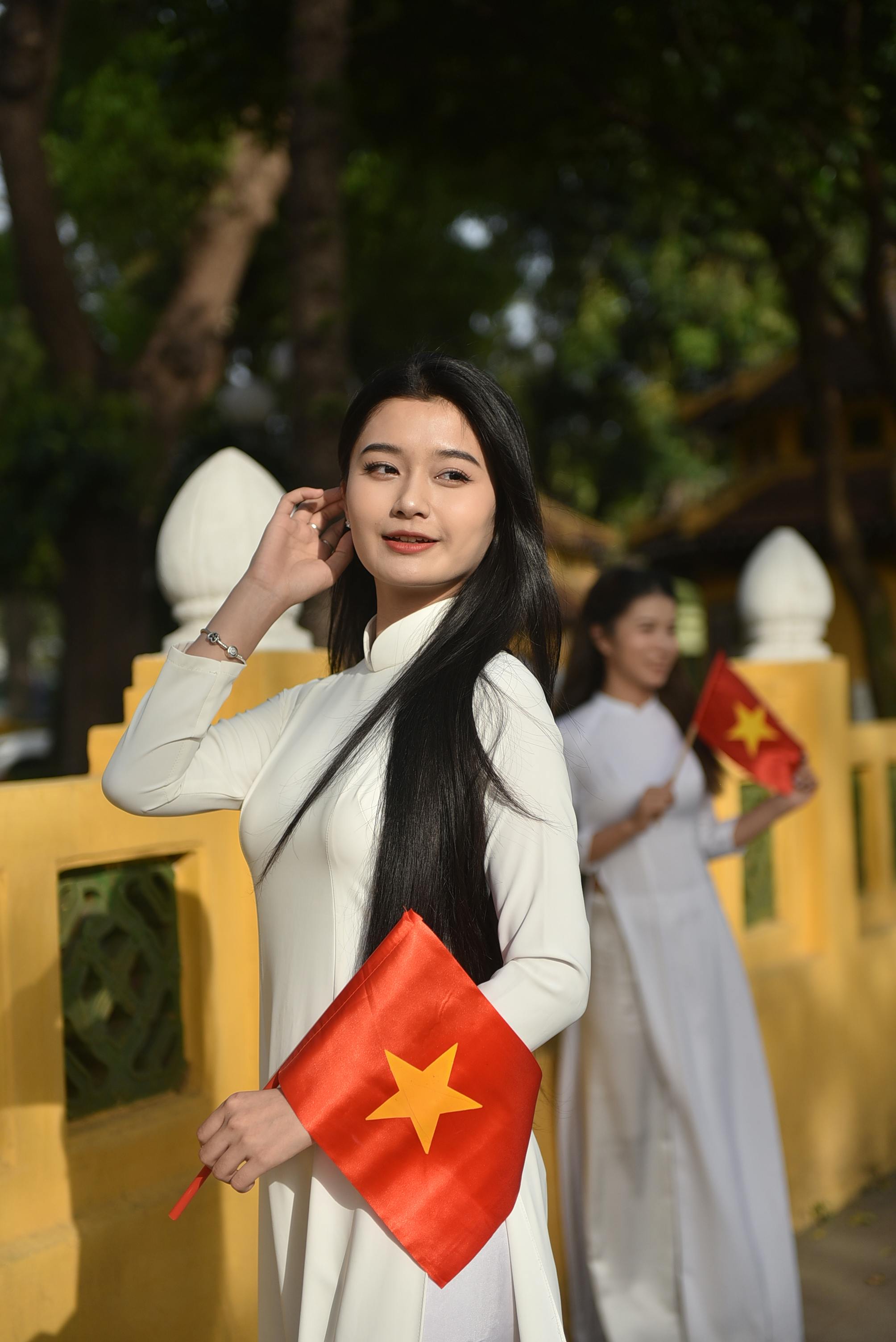 Vietnamese Women in Traditional Ao Dai Holding Flags · Free Stock Photo