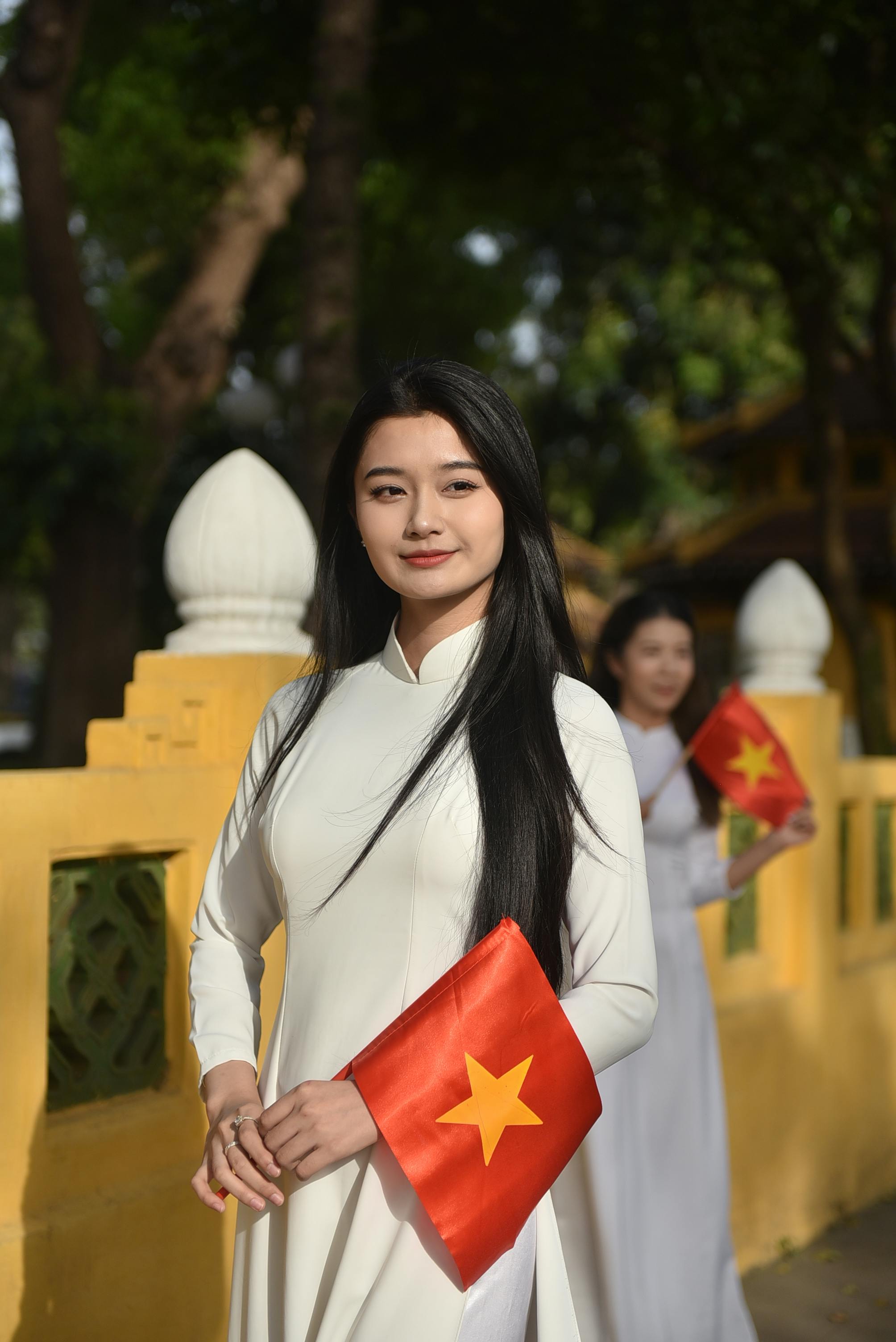 Vietnamese Women in Traditional Ao Dai with Flags · Free Stock Photo